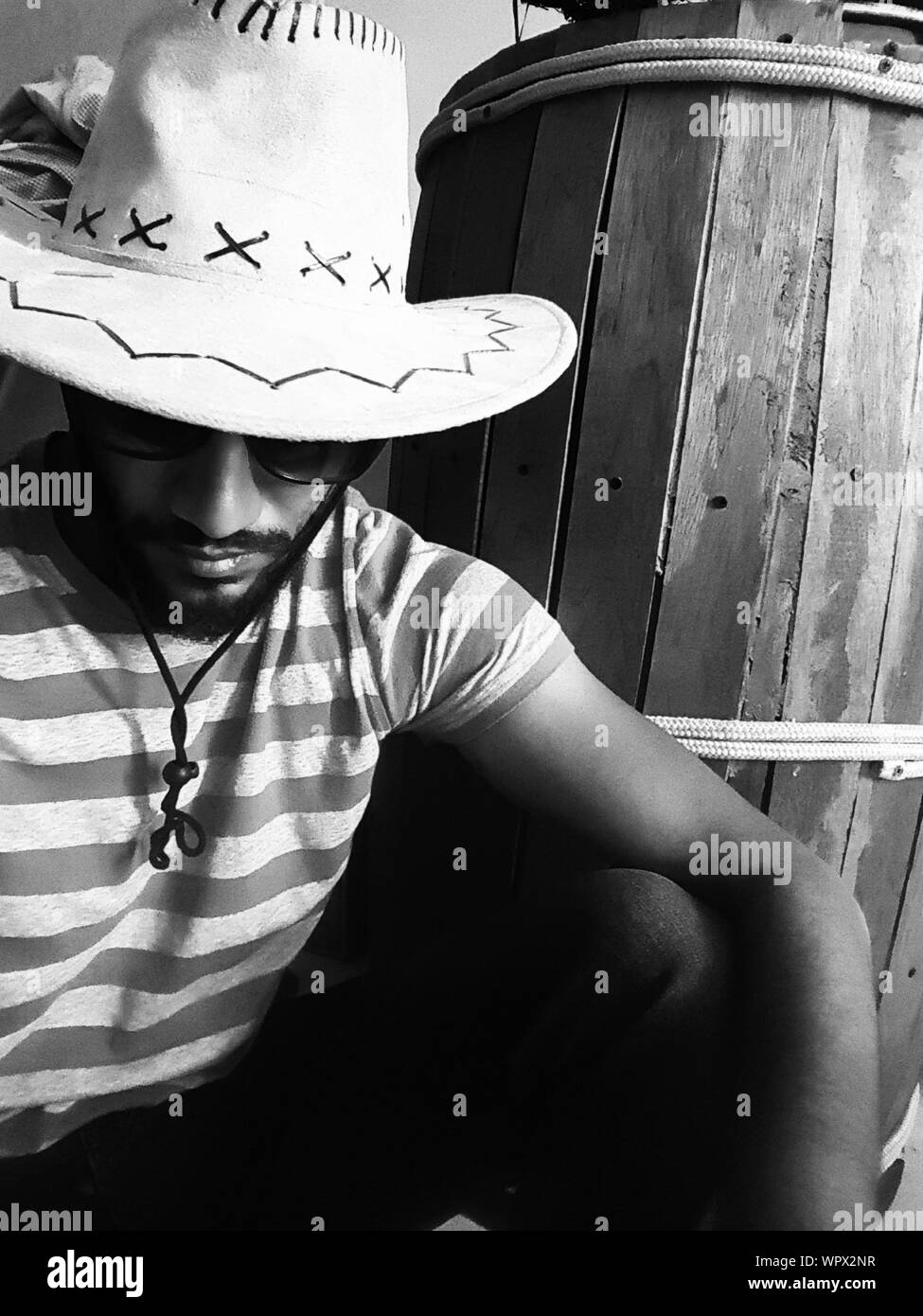 Cowboy Sitting By Wooden Barrel Stock Photo - Alamy