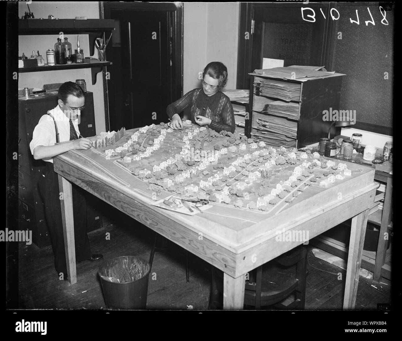 Man and woman creating model of streets with houses Stock Photo - Alamy