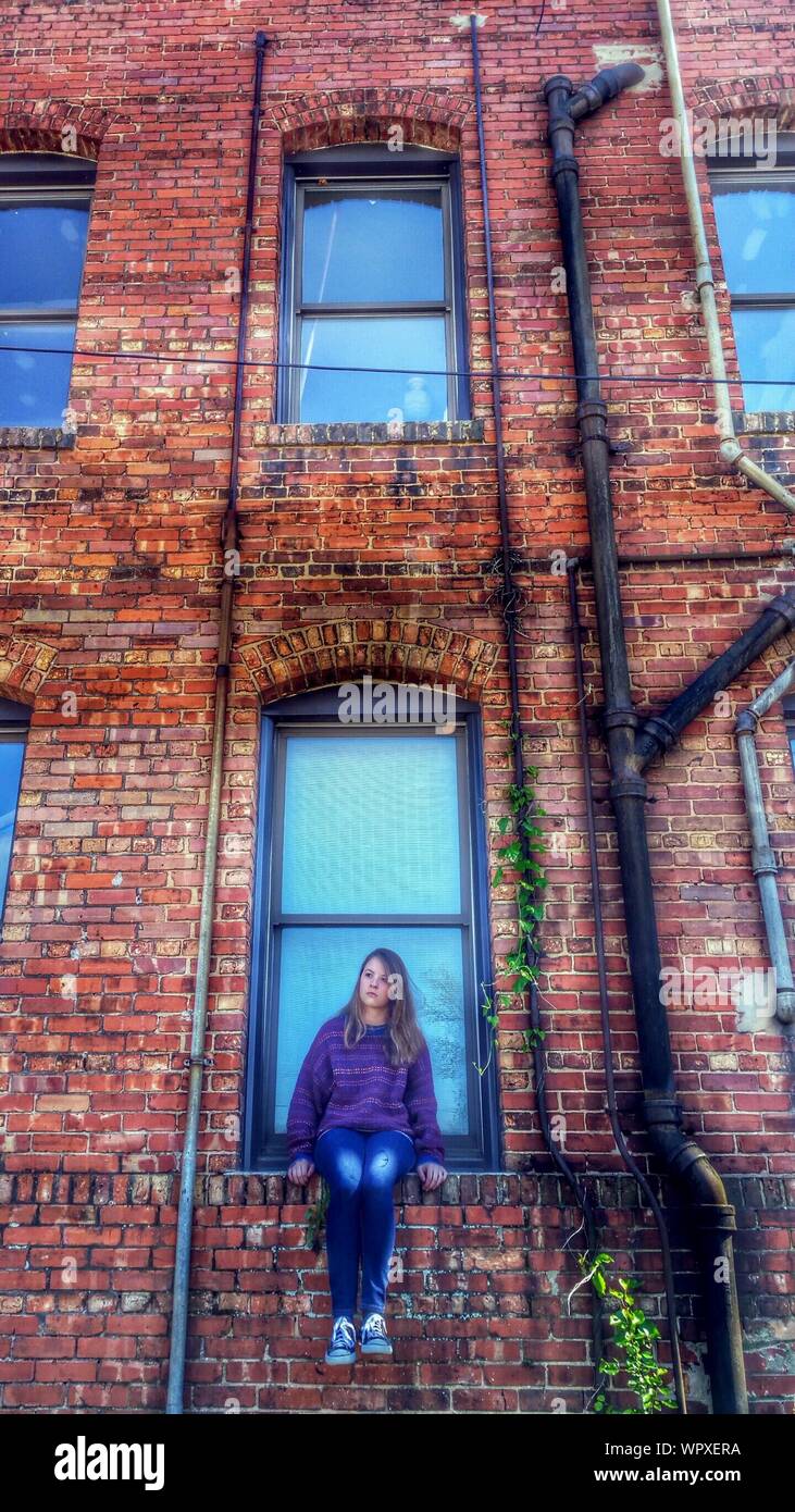 Girl sitting on wall low angle hi-res stock photography and images - Alamy