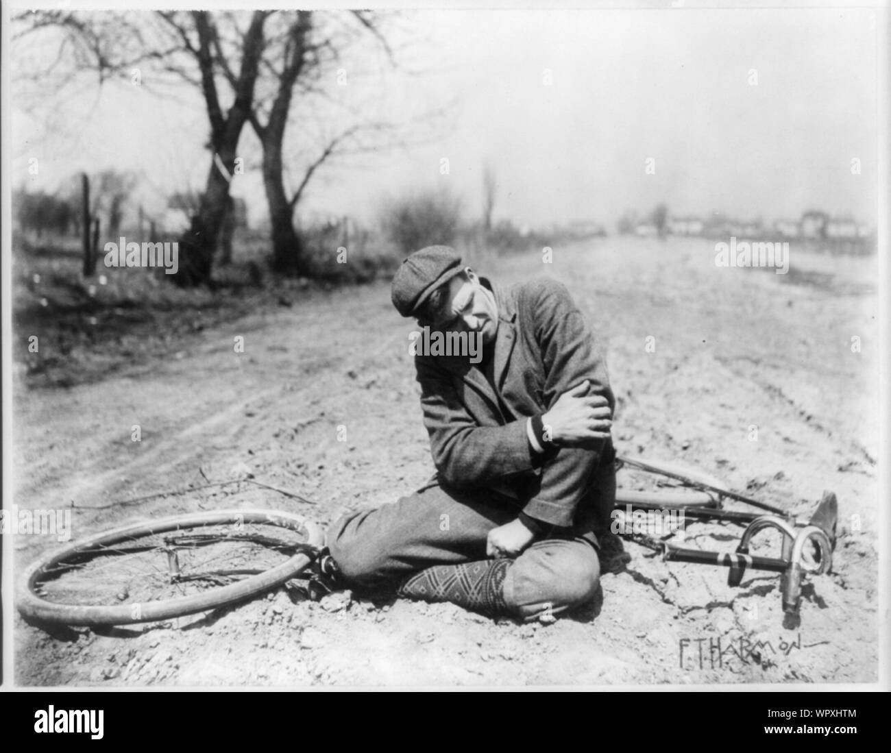 Man fallen from bicycle, sitting on ground Stock Photo - Alamy
