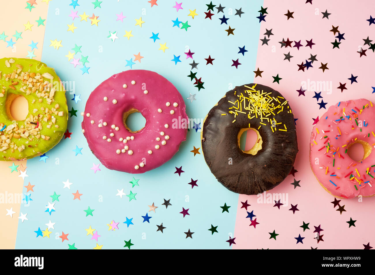 round donuts with various fillings and sprinkles on an abstract color ...