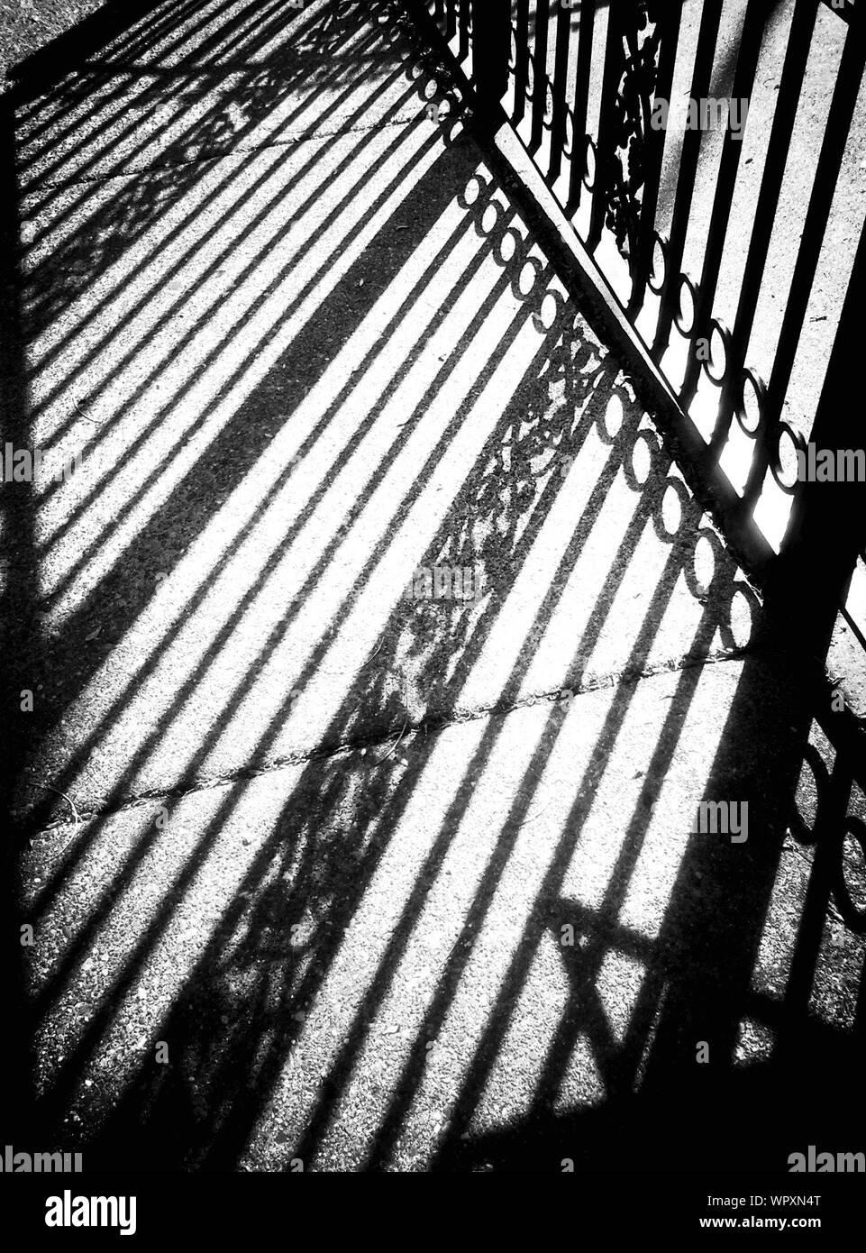 Shadow Of Gate On Street Stock Photo - Alamy