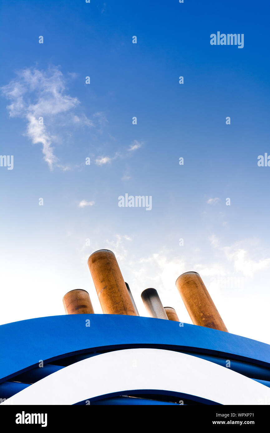 Side view of ship exhaust funnel pipes and wavy blue cowling against ...