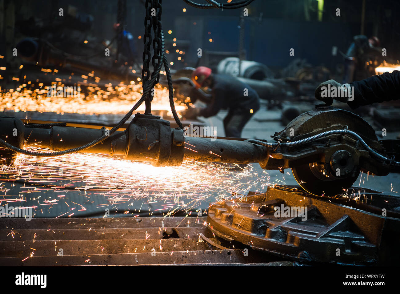 Industrial worker cutting and welding metal with many sharp sparks ...