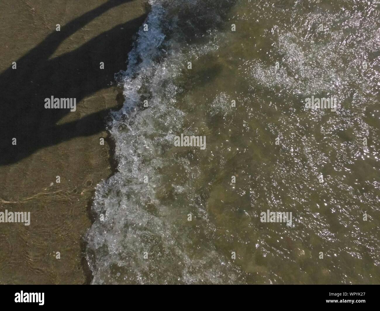 Shadow Of Person On Water At Beach Stock Photo - Alamy