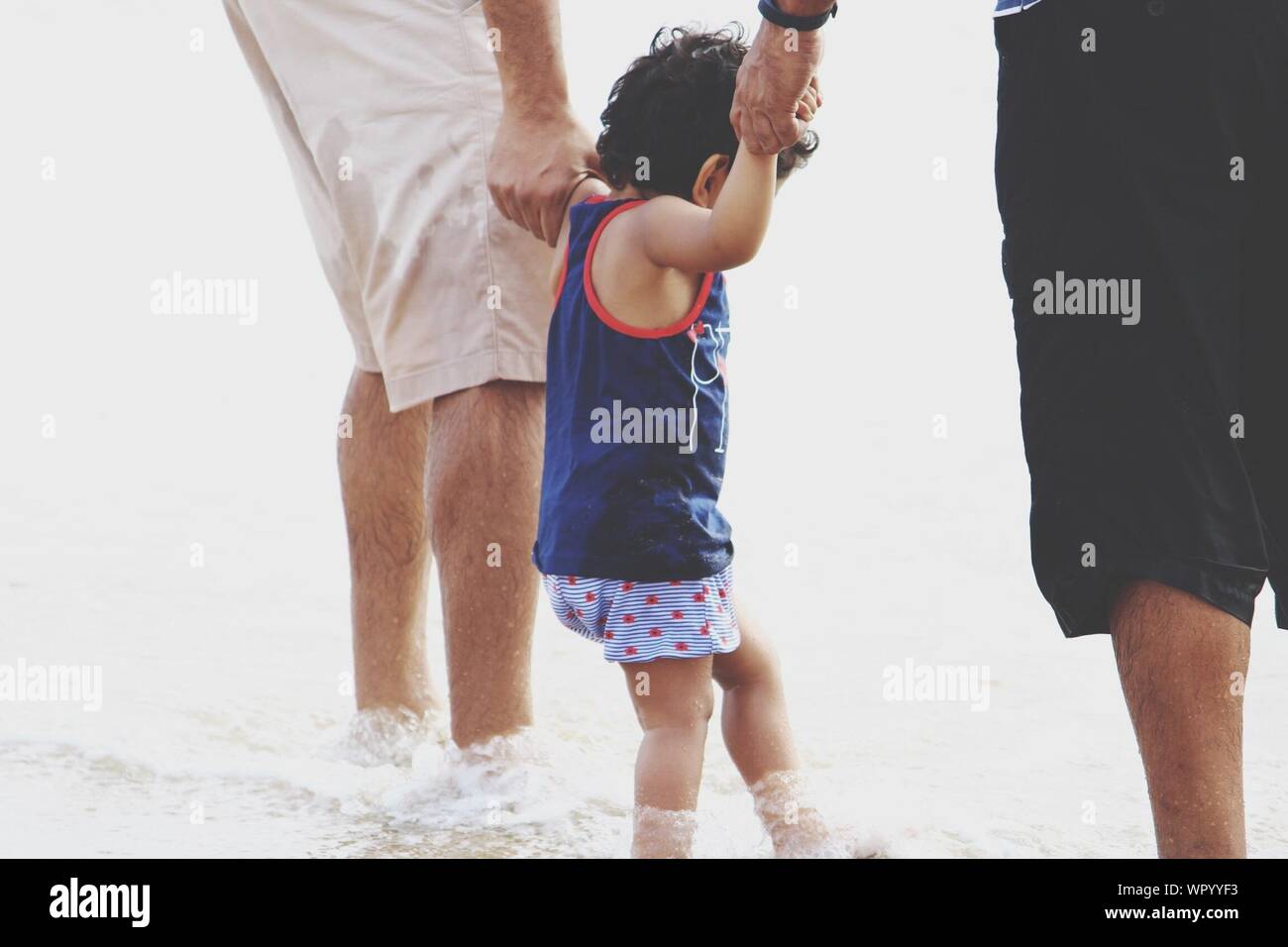 Two Men And Young Boy Standing In Sea Stock Photo - Alamy