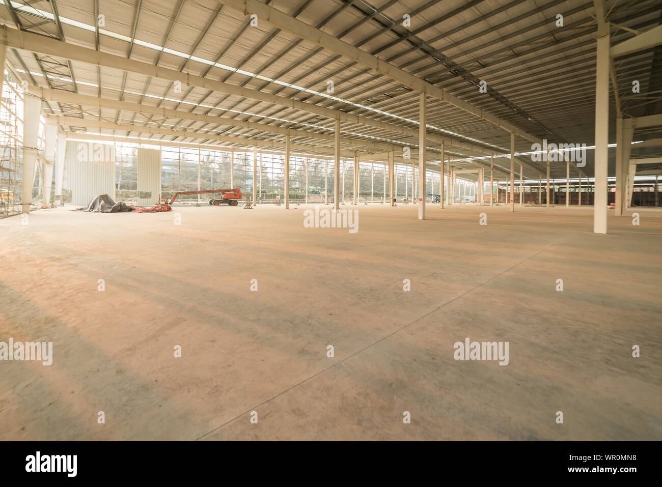 Empty building with a lift machine in the distance Stock Photo - Alamy