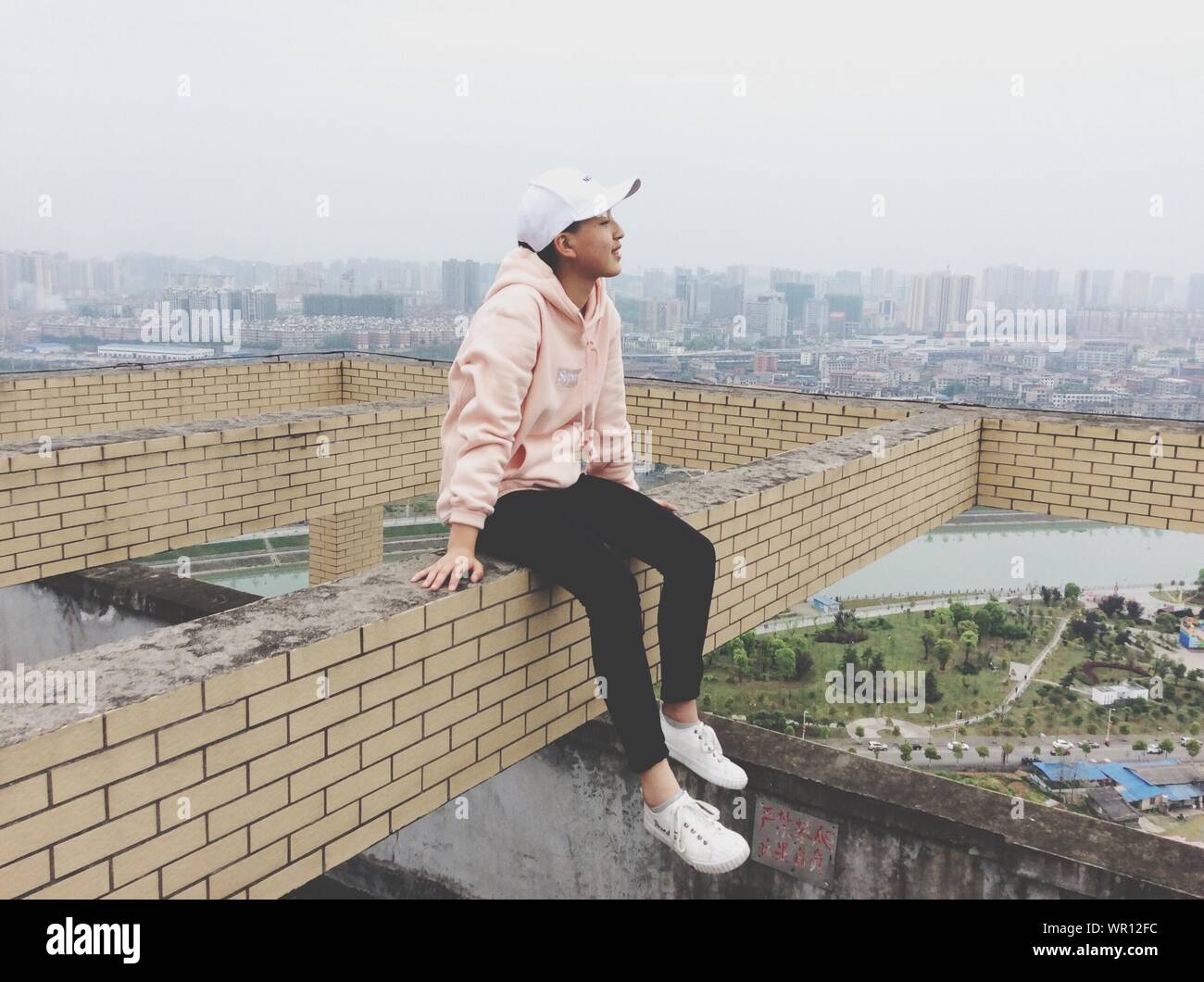 Man sitting on brick wall hi-res stock photography and images - Alamy