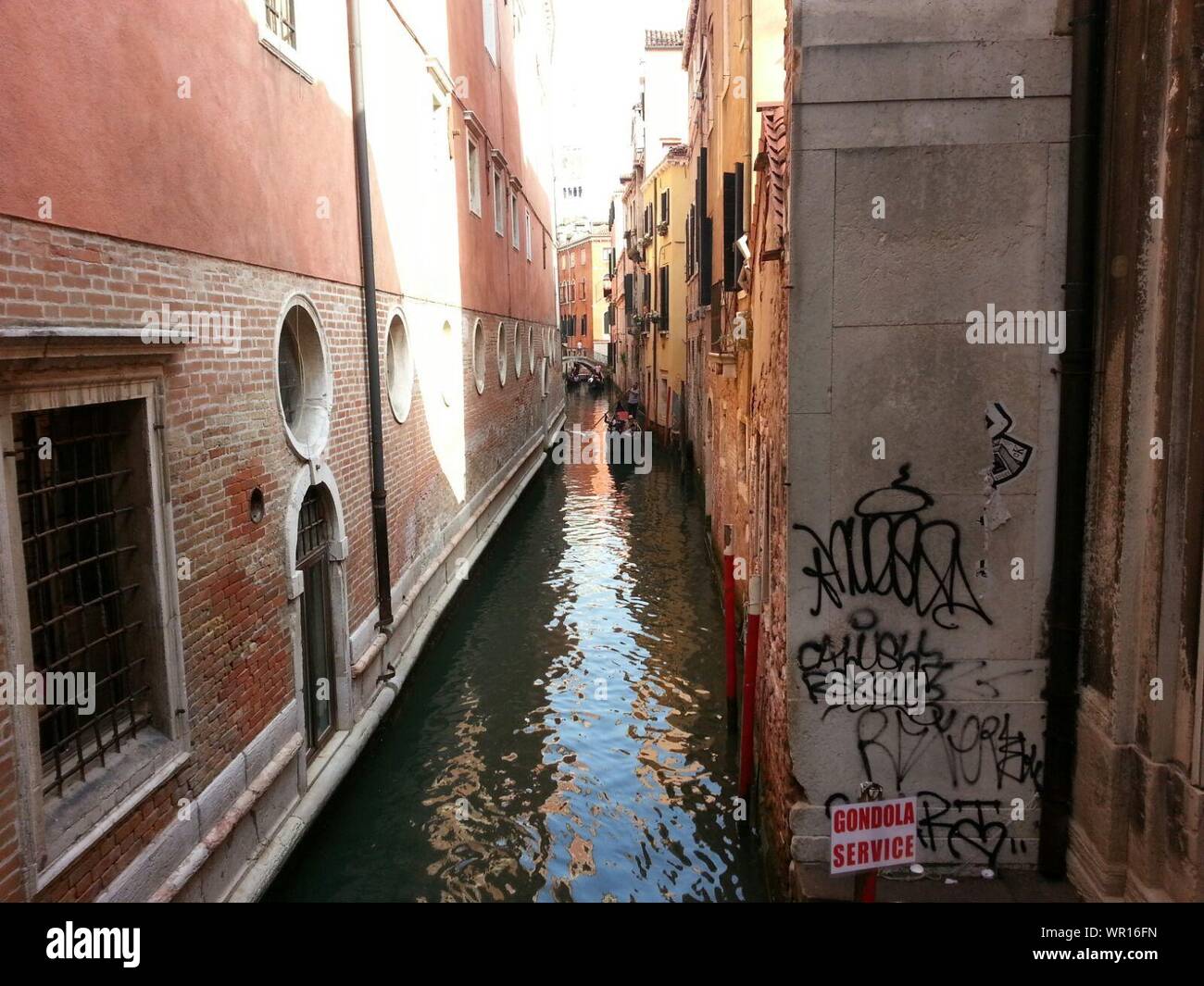 Graffiti On Wall Of Building By Canal In City Stock Photo - Alamy