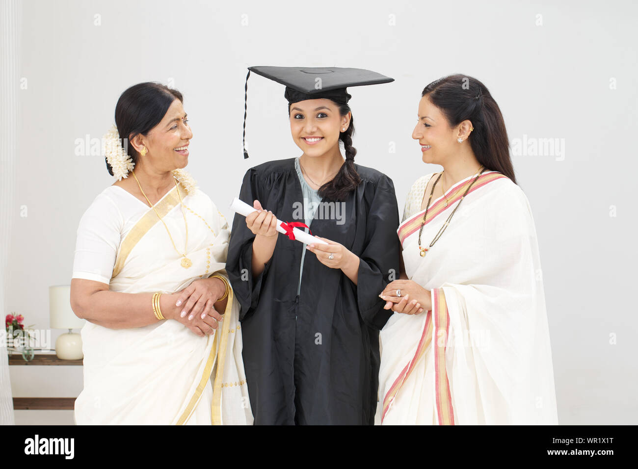 Graduate student standing with her parents and smiling Stock Photo - Alamy