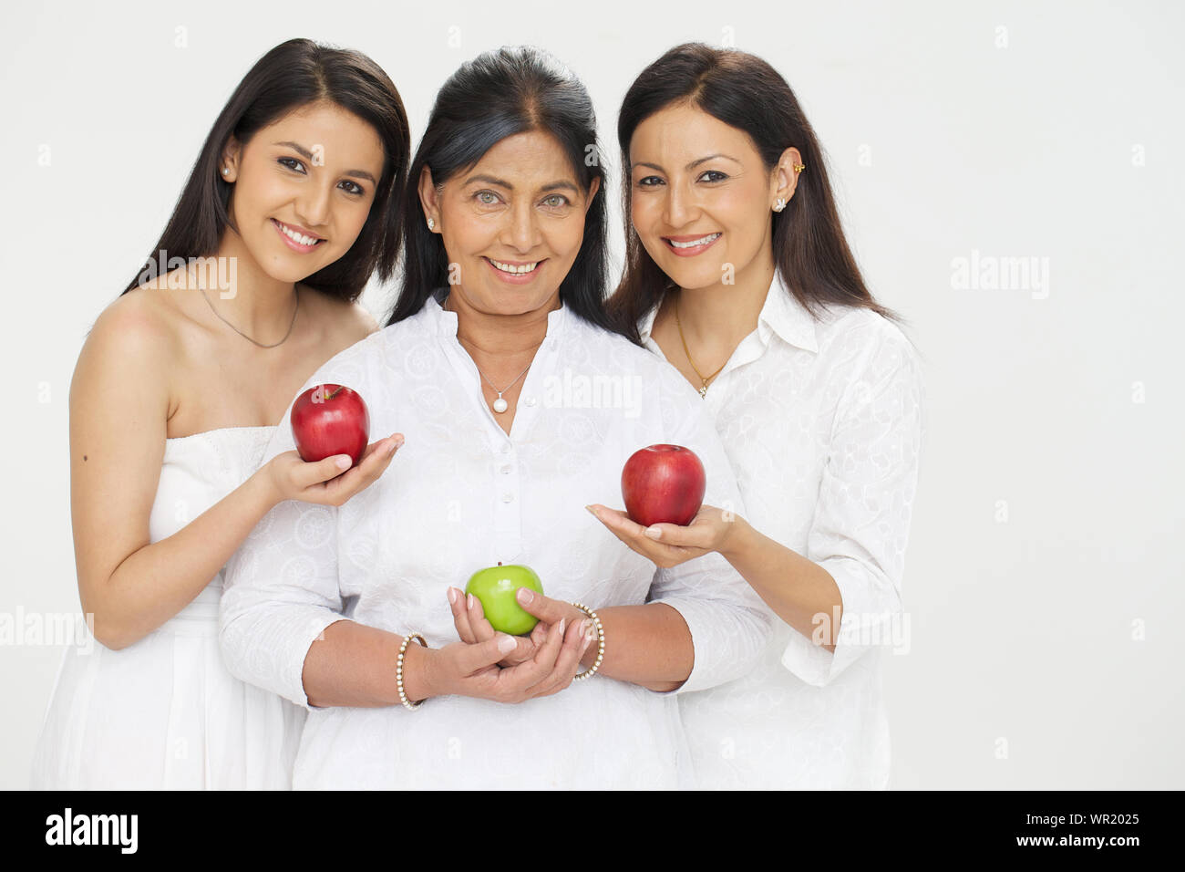 Three generation of women holding apples Stock Photo - Alamy