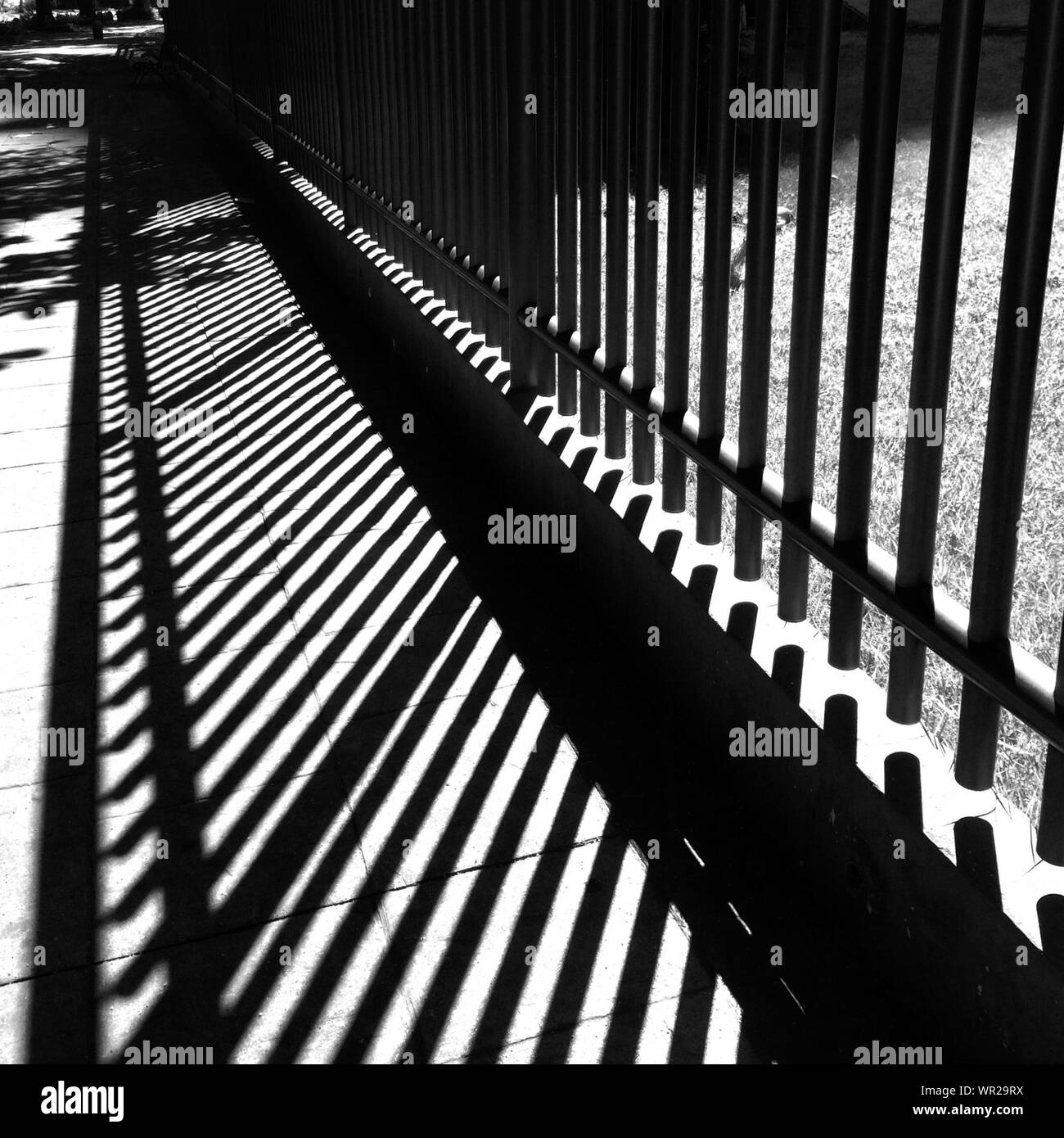 Shadow of fence on the sidewalk hi-res stock photography and images - Alamy