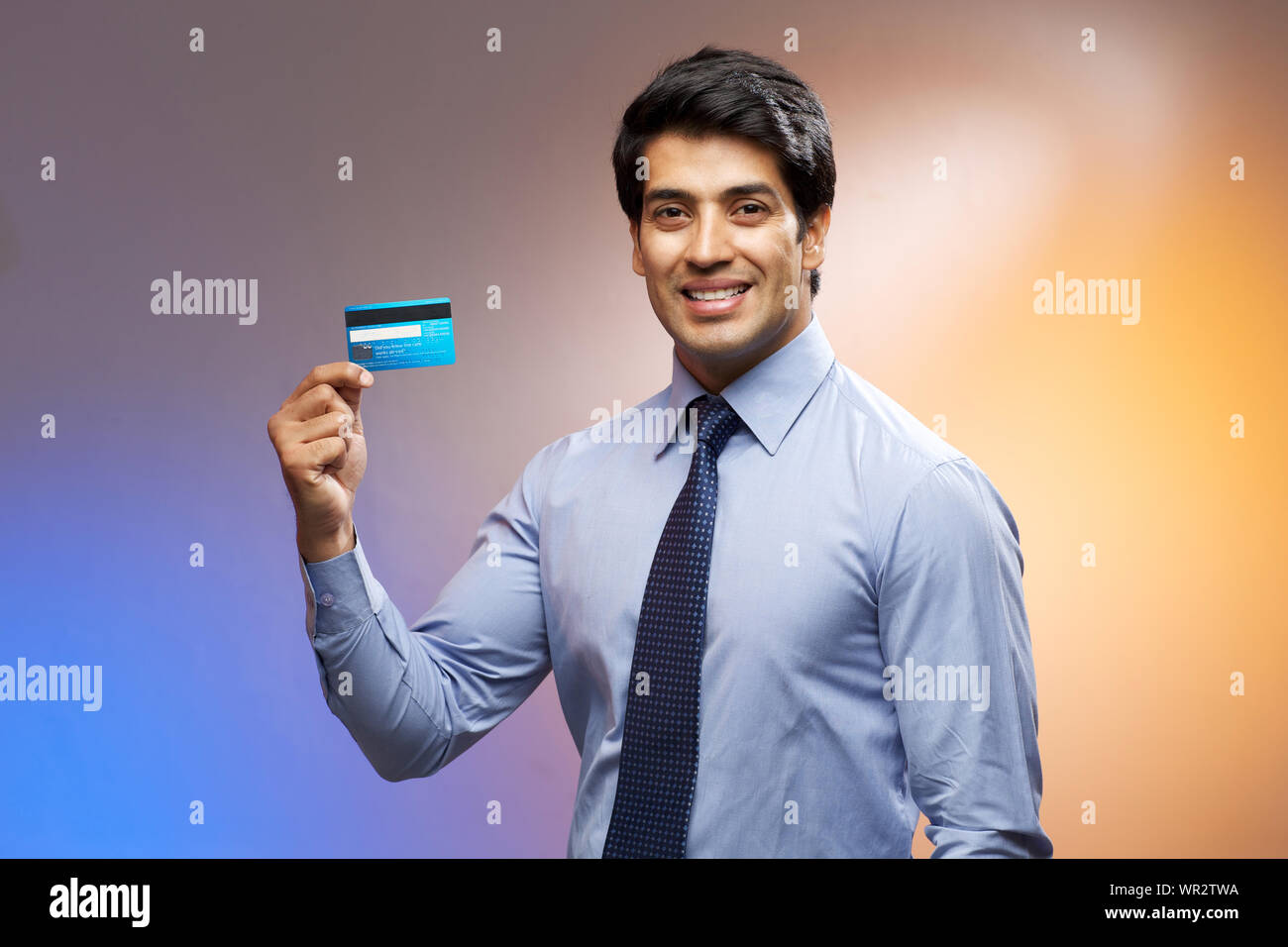 Businessman showing a credit card and smiling Stock Photo - Alamy