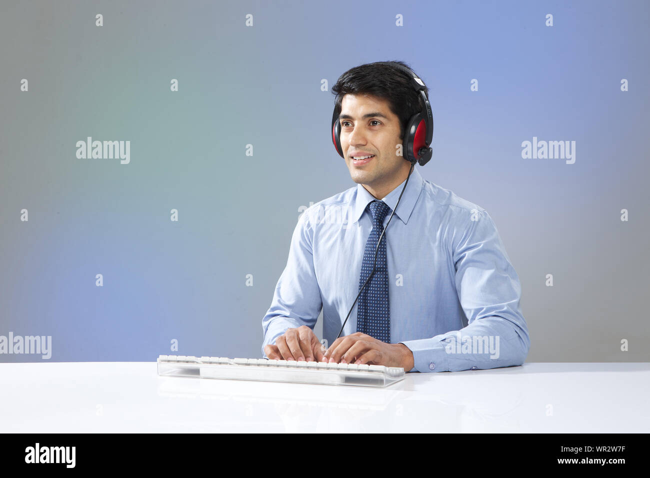 Businessman using wireless keyboard and wearing a headset Stock Photo ...