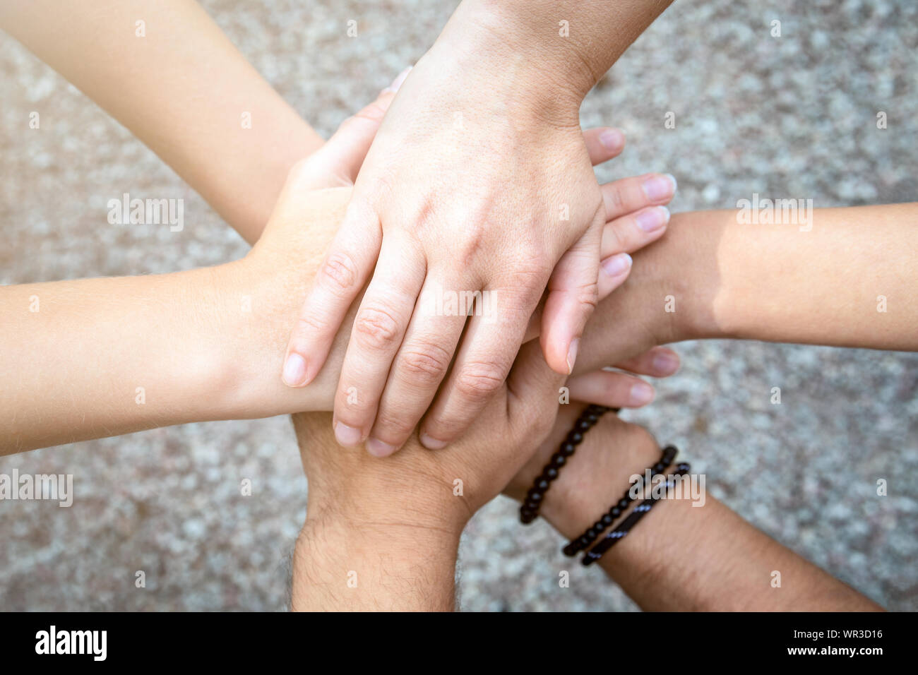 Close up top view of people putting their hands together Stock Photo ...