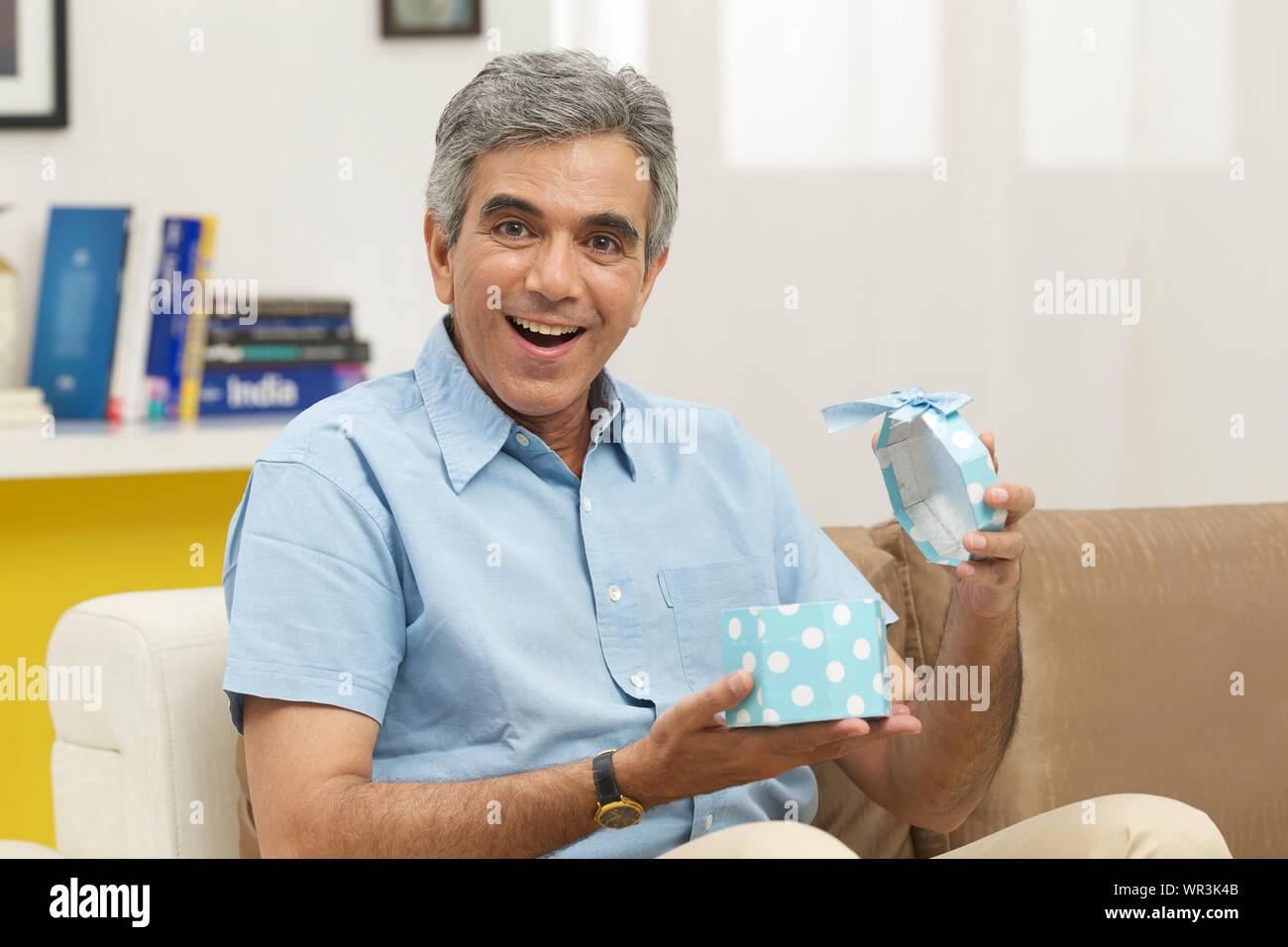 Senior man opening a gift box and smiling Stock Photo - Alamy