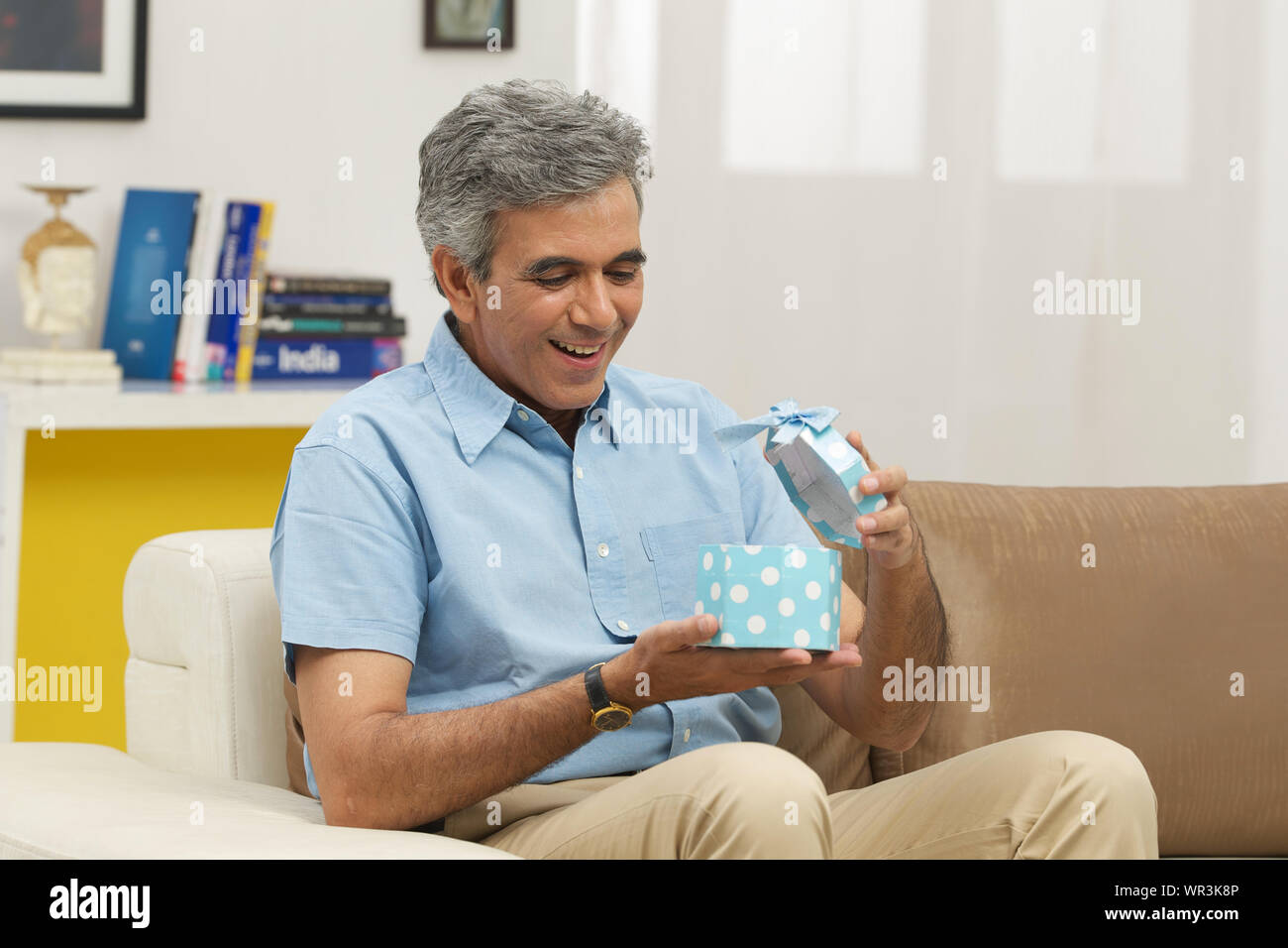 Senior man opening a gift box and smiling Stock Photo - Alamy