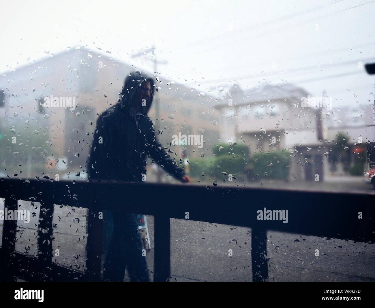 Man Walking Along Street In Rain Stock Photo - Alamy
