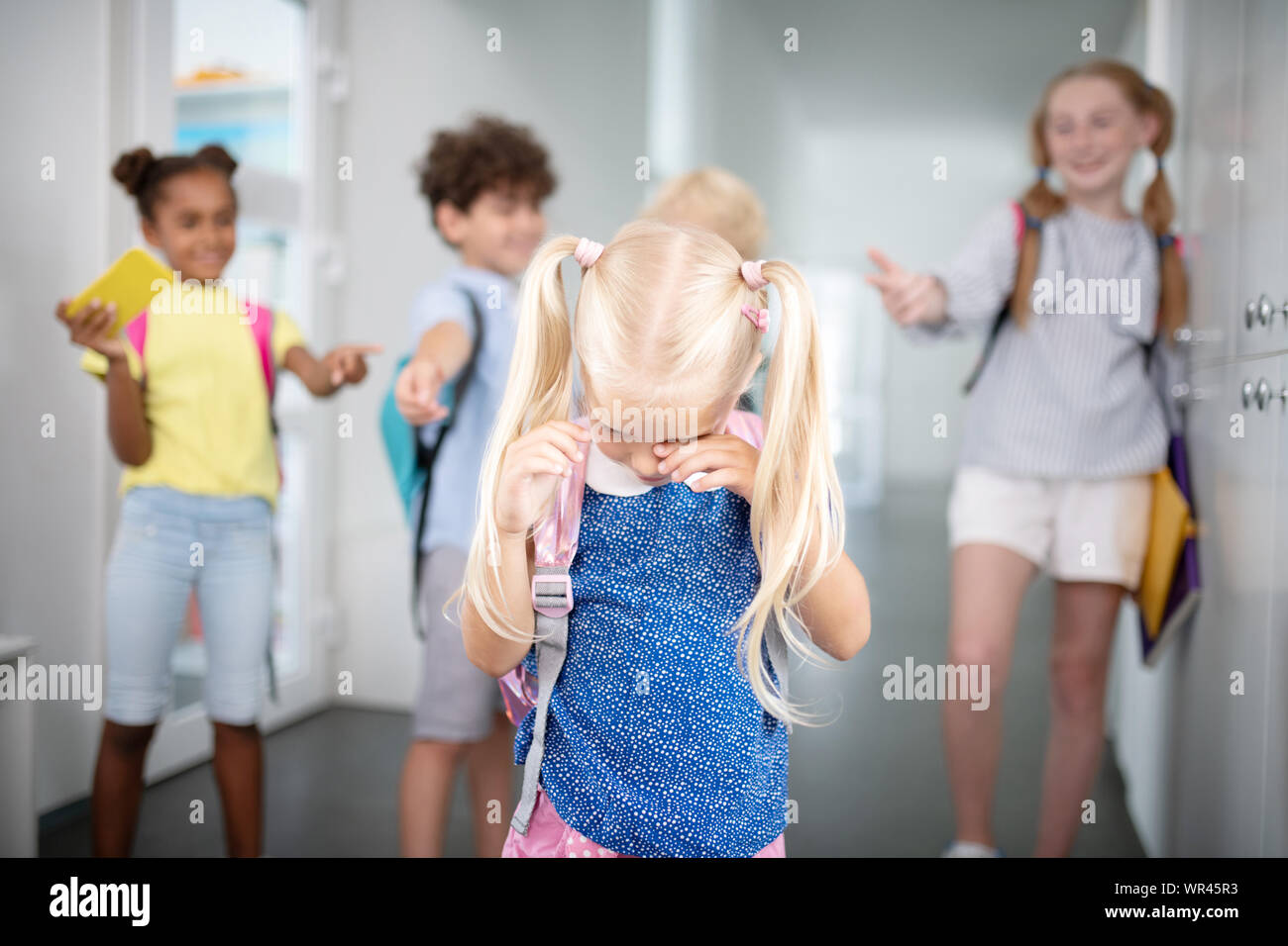 Little girl crying while feeling offended by classmates Stock Photo - Alamy