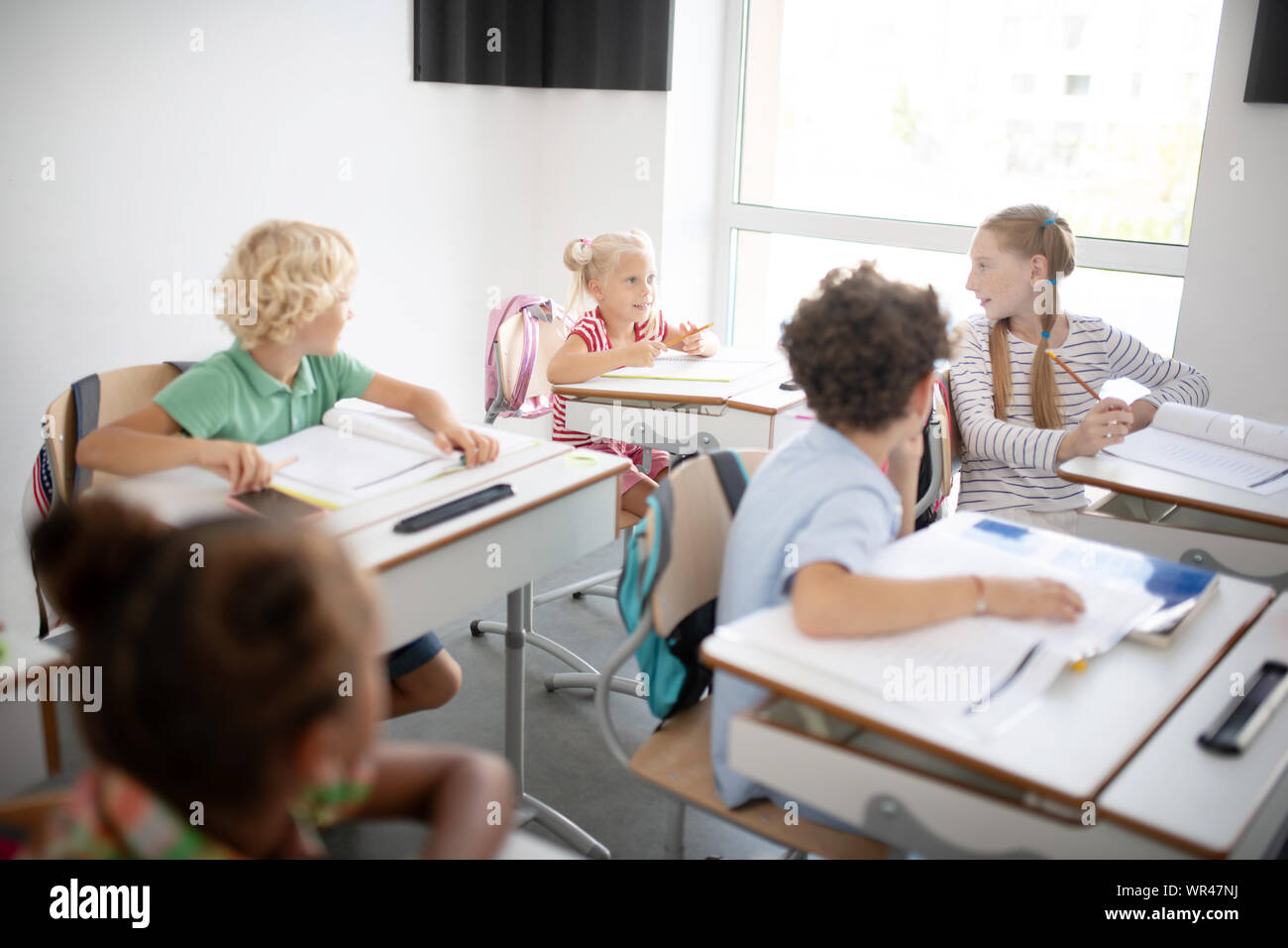 Pupils talking to each other while having little break Stock Photo - Alamy