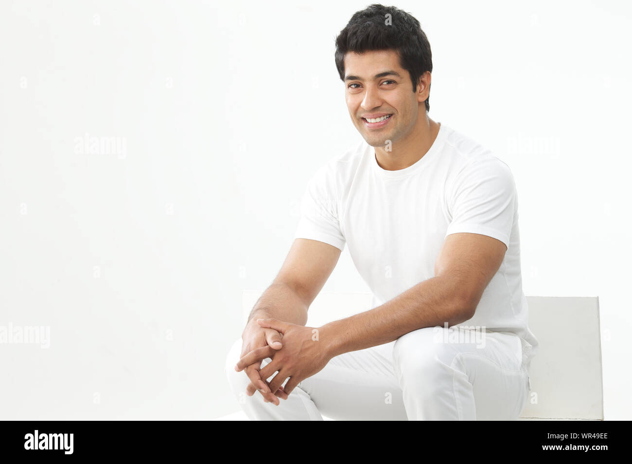 young man sitting on steps and smiling Stock Photo - Alamy