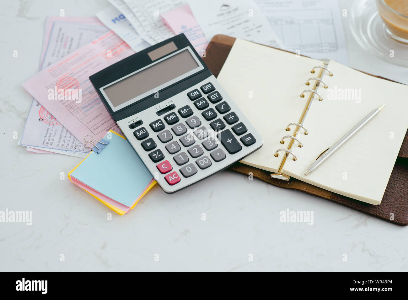 Closed up and soft focus on pen laying on paperwork with calculator for ...