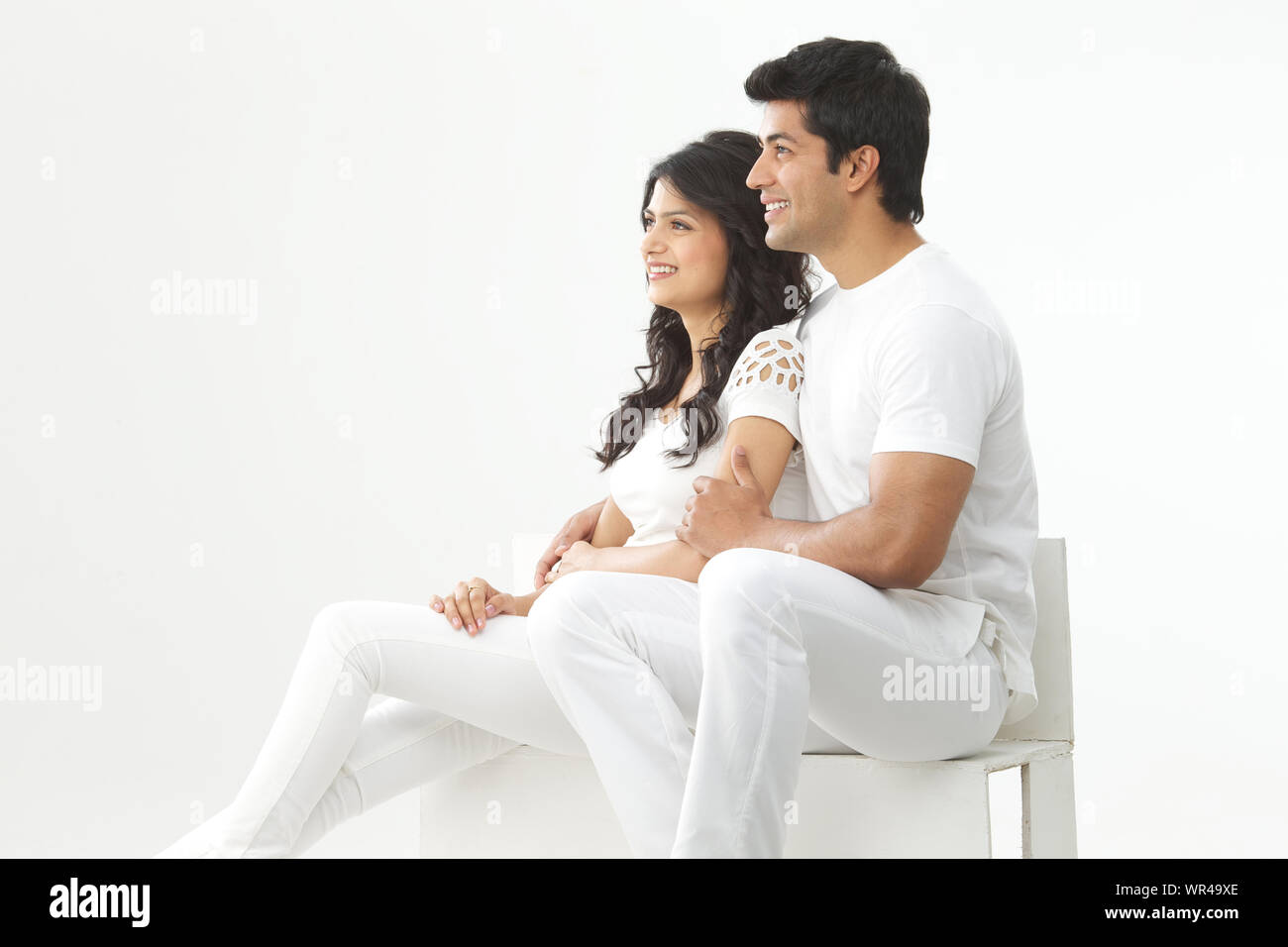Young couple sitting together and smiling Stock Photo - Alamy