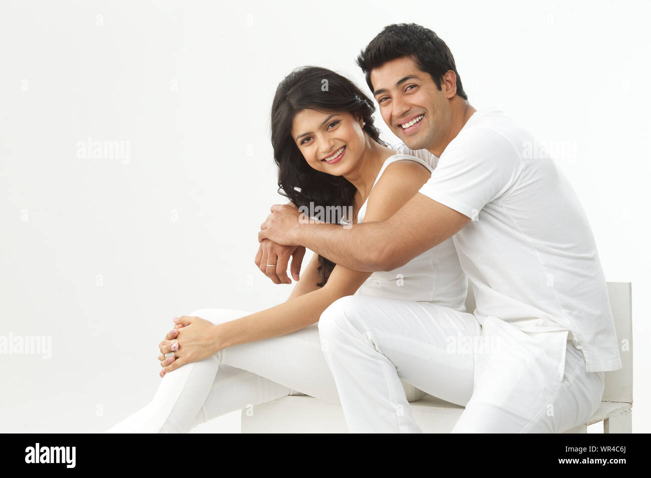 Young couple sitting together and smiling Stock Photo - Alamy