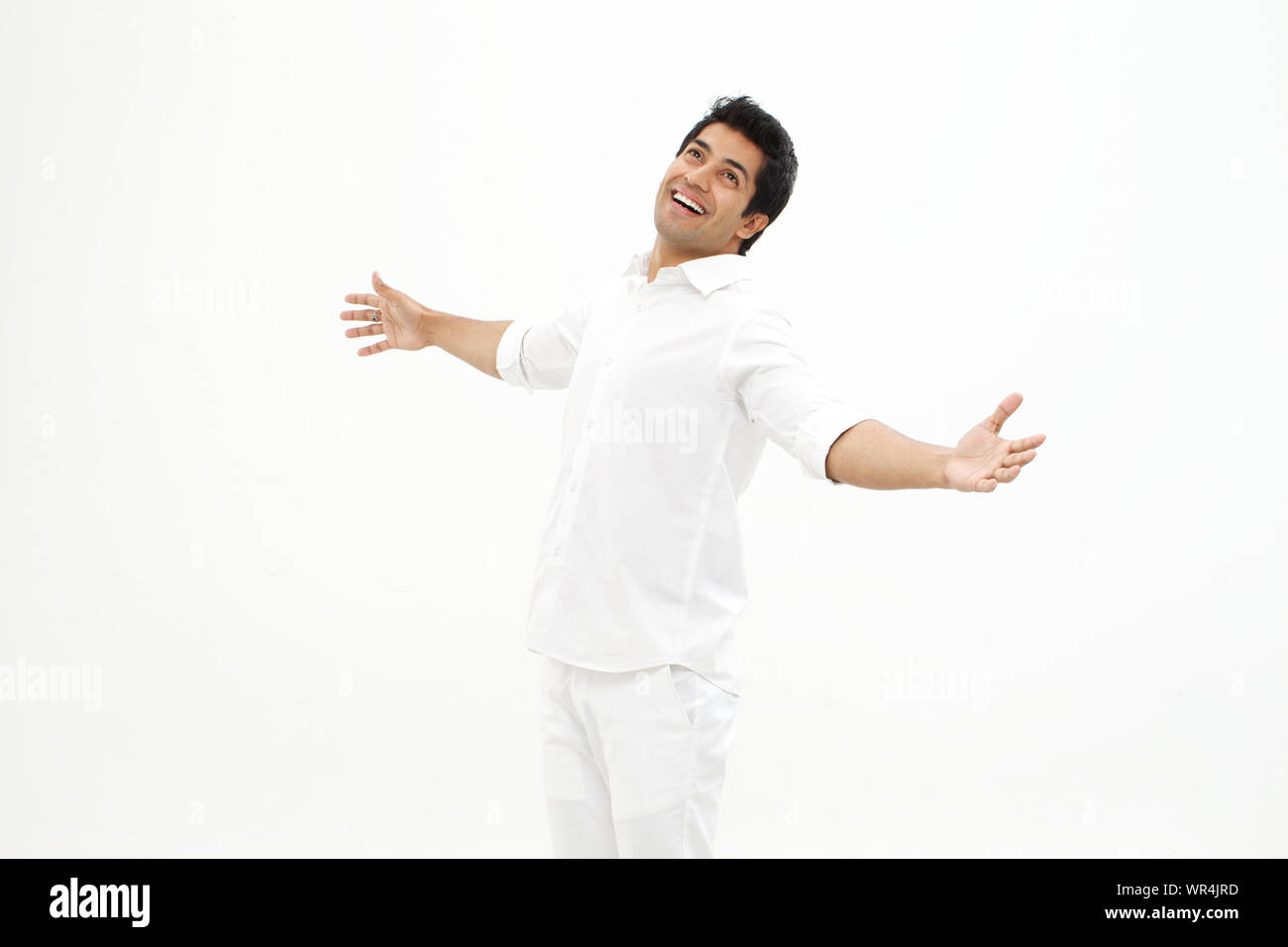 Young man smiling with his arm outstretched Stock Photo - Alamy