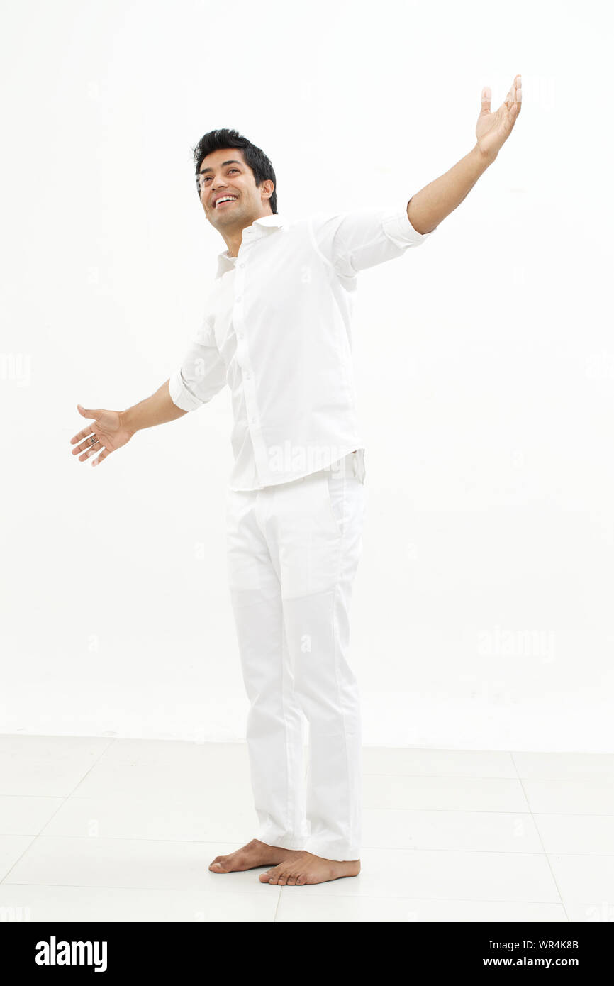 Young man smiling with his arm outstretched Stock Photo - Alamy