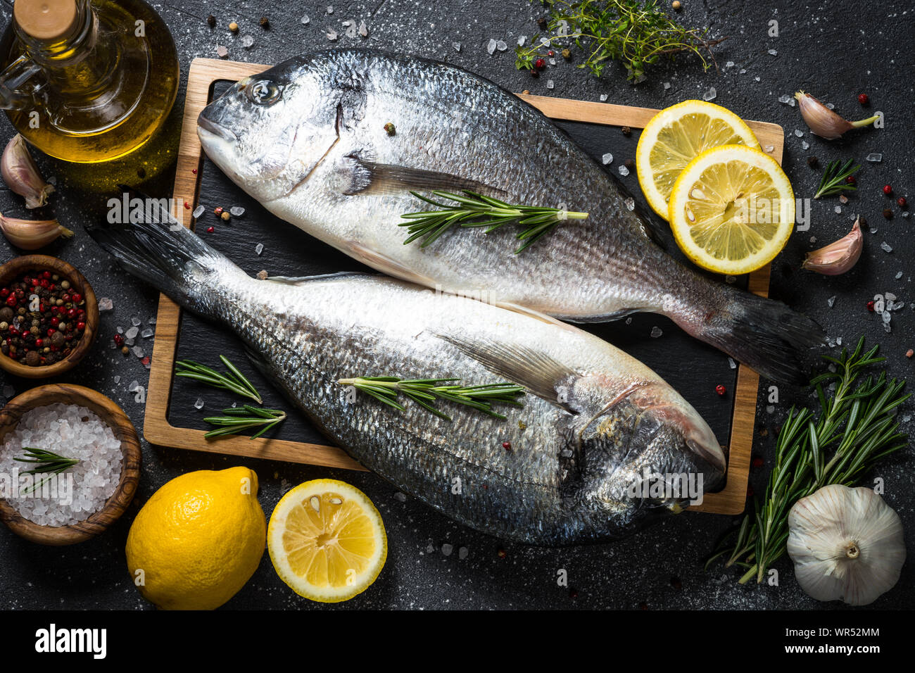 Raw dorado fish on black Stock Photo - Alamy