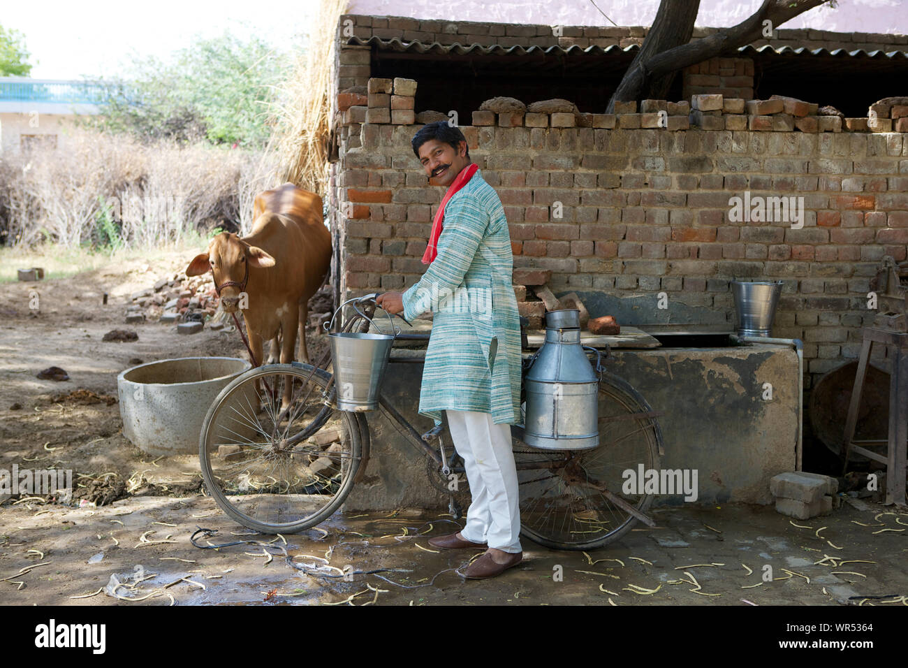 Milkman delivering milk on a cycle Stock Photo - Alamy