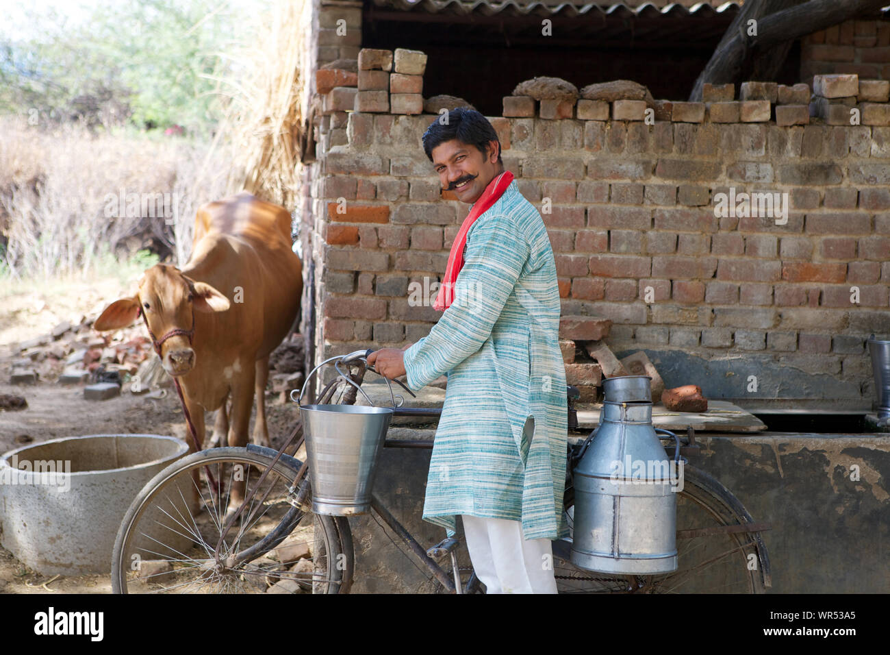 Milkman delivering milk on a cycle Stock Photo - Alamy