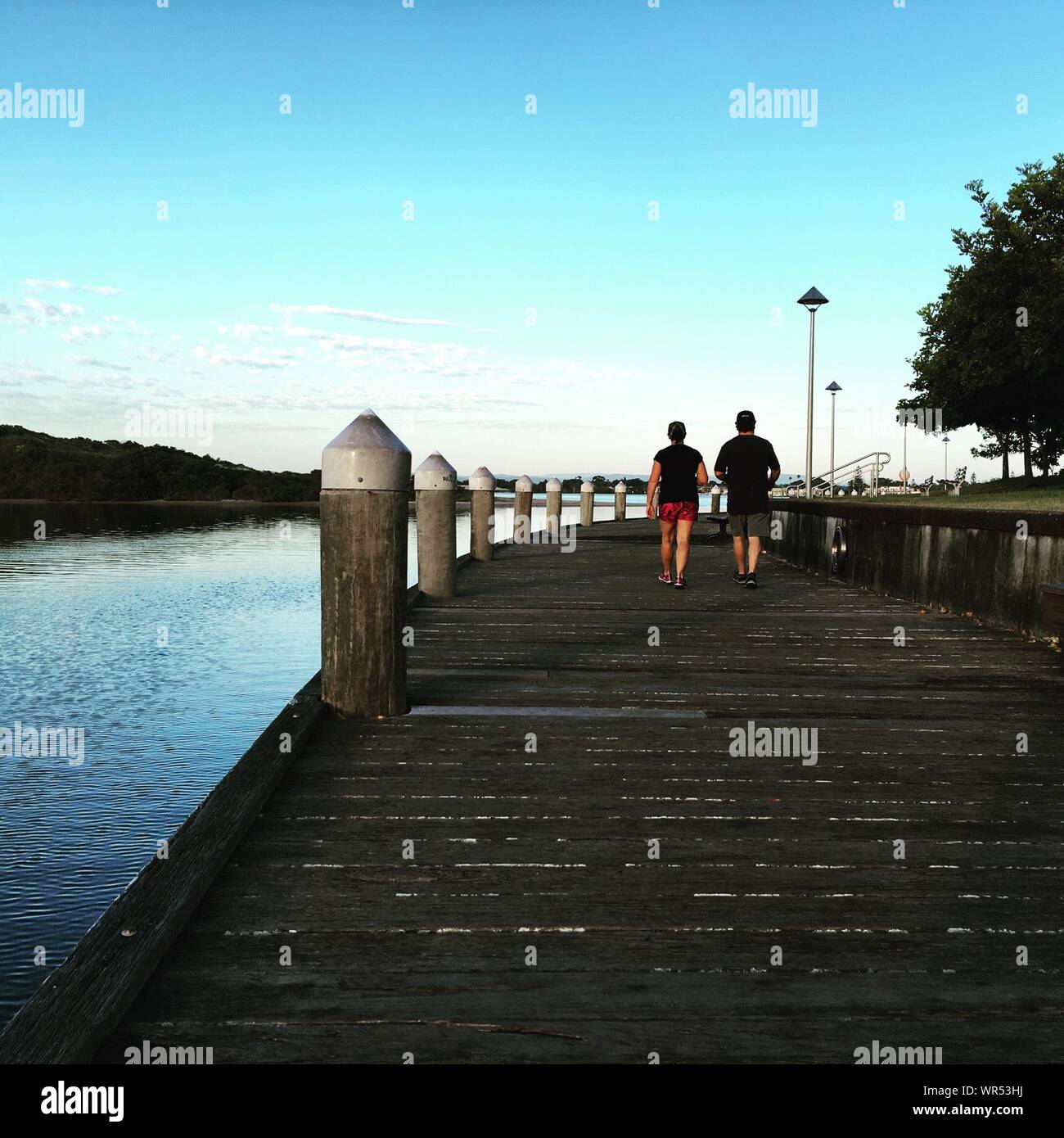Rear View Of People Walking On Jetty By The Lake Stock Photo - Alamy