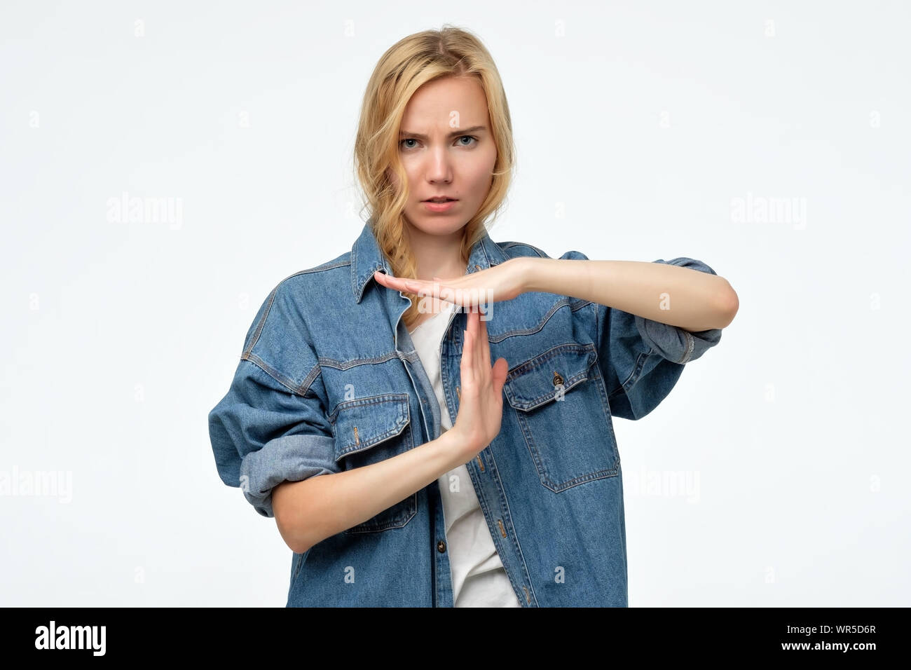 young blonde caucasian woman showing time out sign over white ...