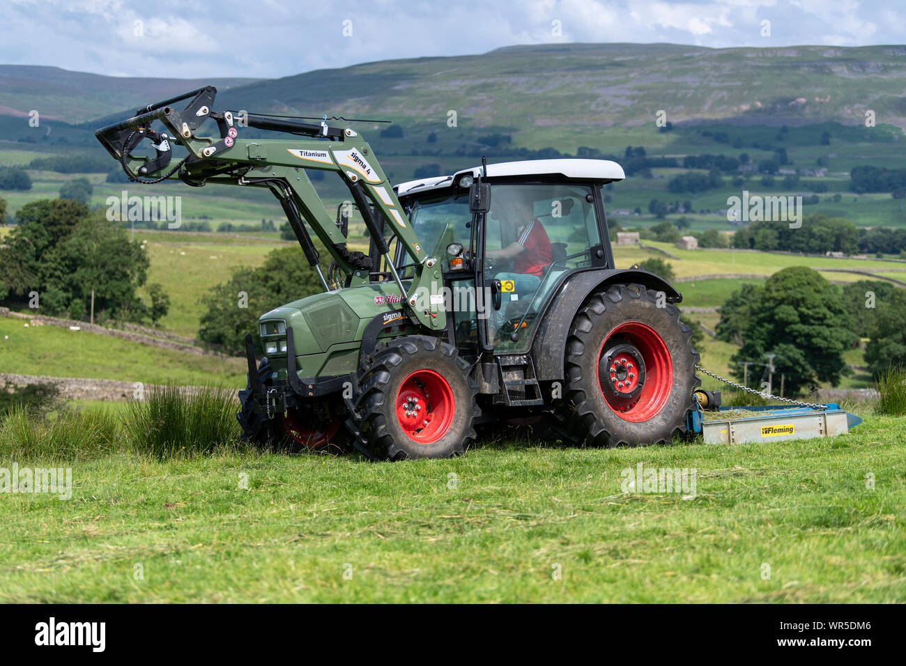 Topping overgrown grass on an upland pasture with a Hurlimann tractor ...