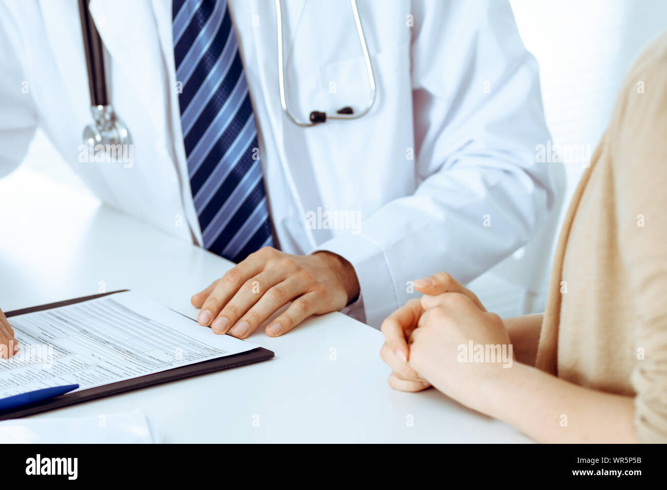 Hand of doctor reassuring her female patient. Concepts of medical ...