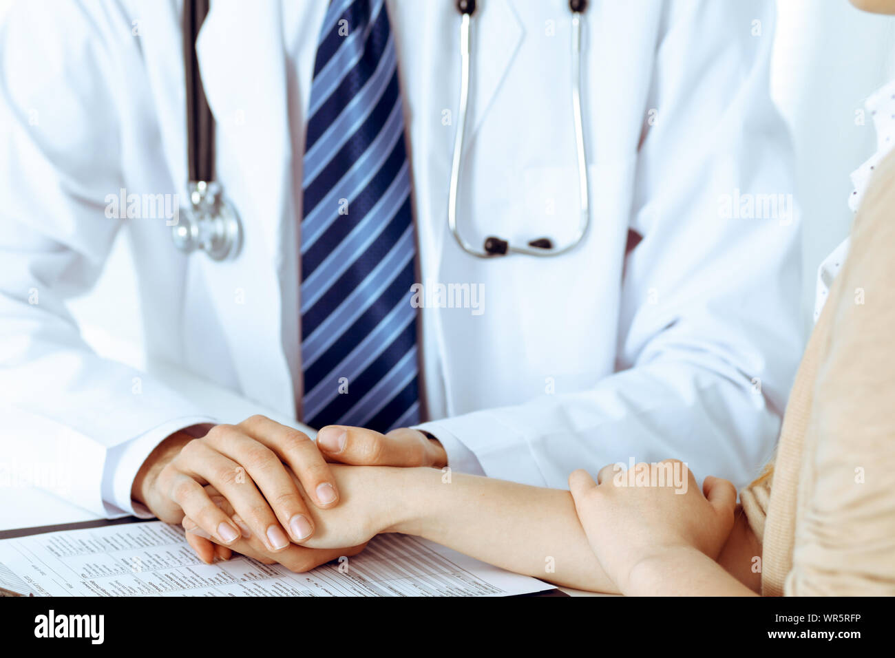 Hand of doctor reassuring her female patient. Concepts of medical ...
