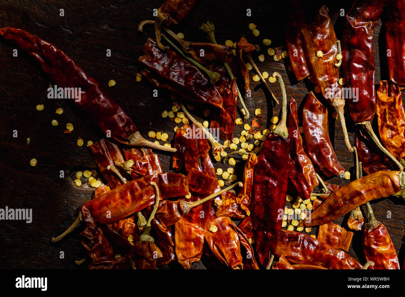 Whole dried chilli peppers with seeds lying in sunlight beam Stock ...