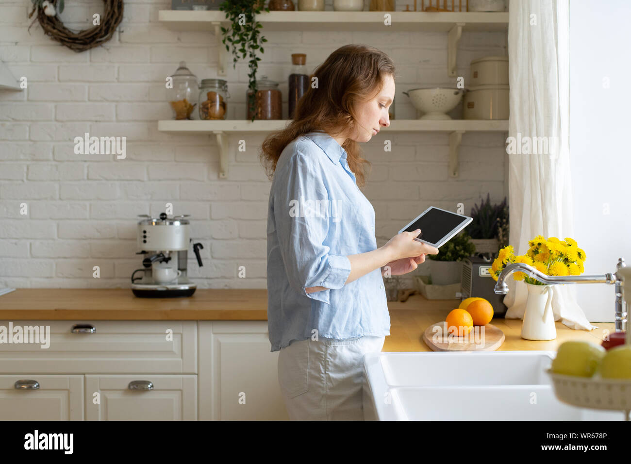 Two young women looking at the tablet screen and smiling Stock Photo ...