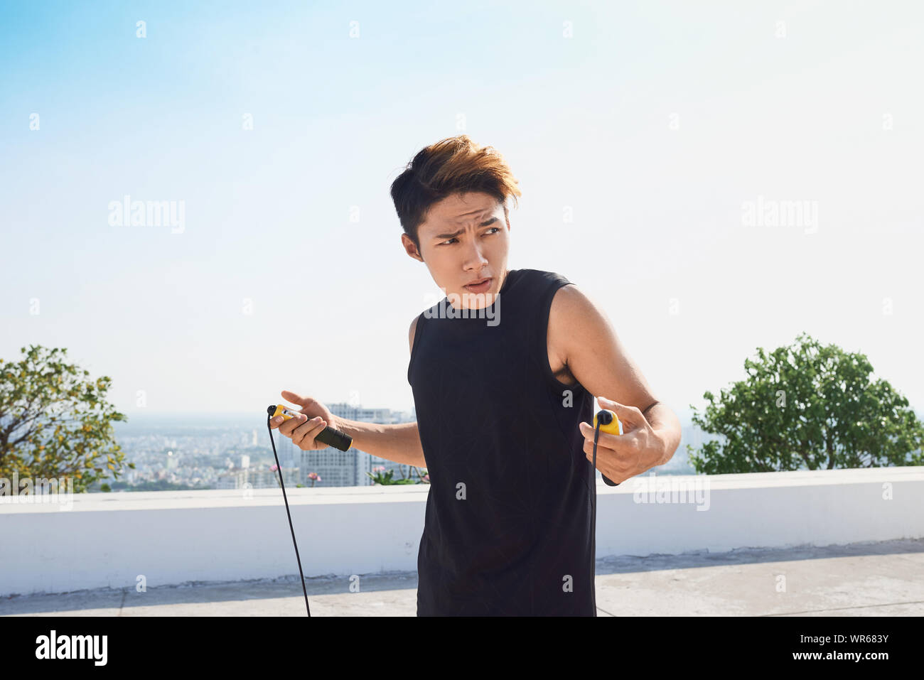 Young man jump roping in the outdoors Stock Photo - Alamy