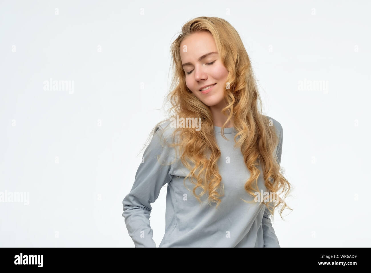 Timid young caucasian female looking down with shy smile, being ...