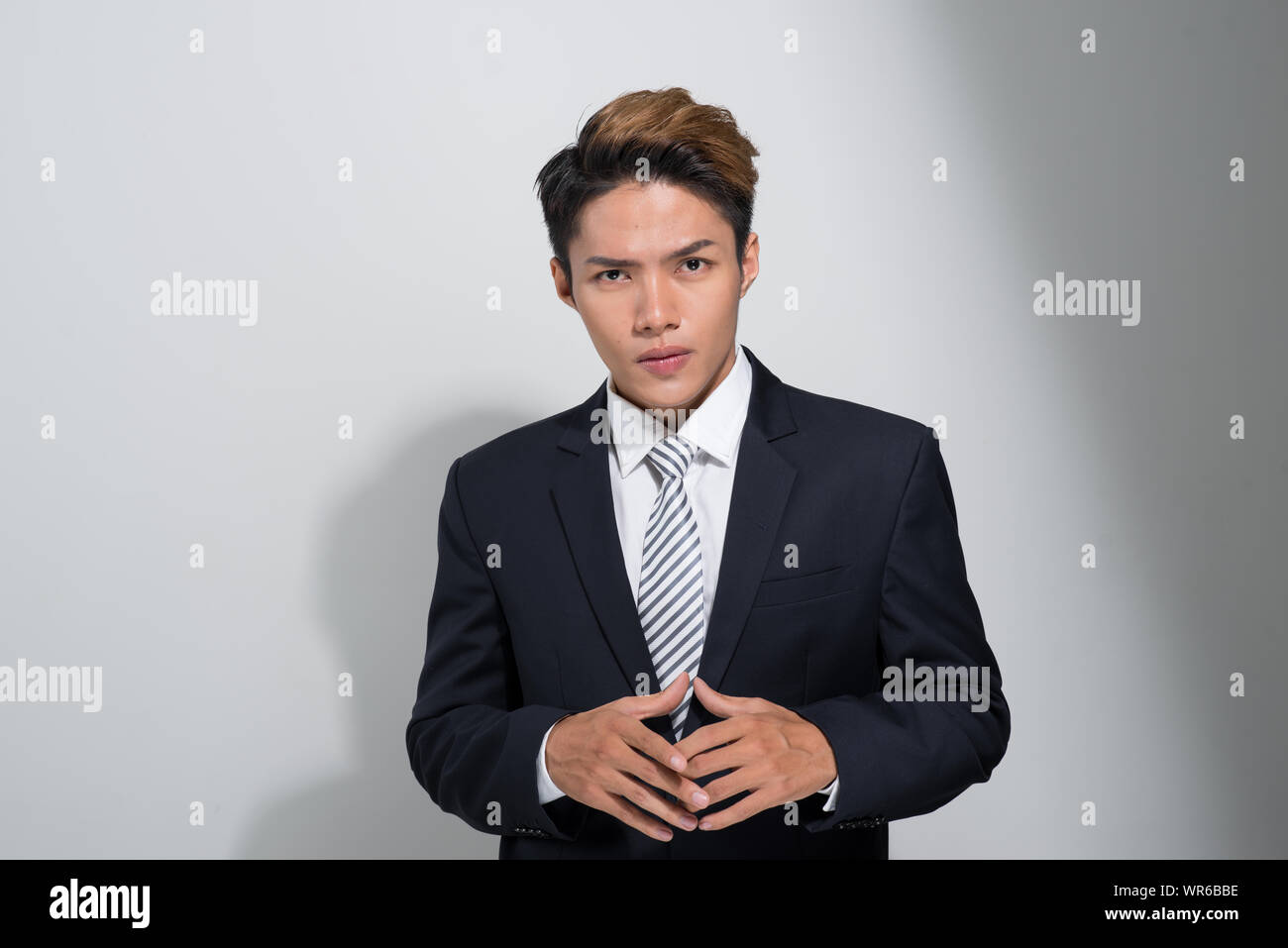 Portrait of young and handsome Asian business man holding a jacket ...