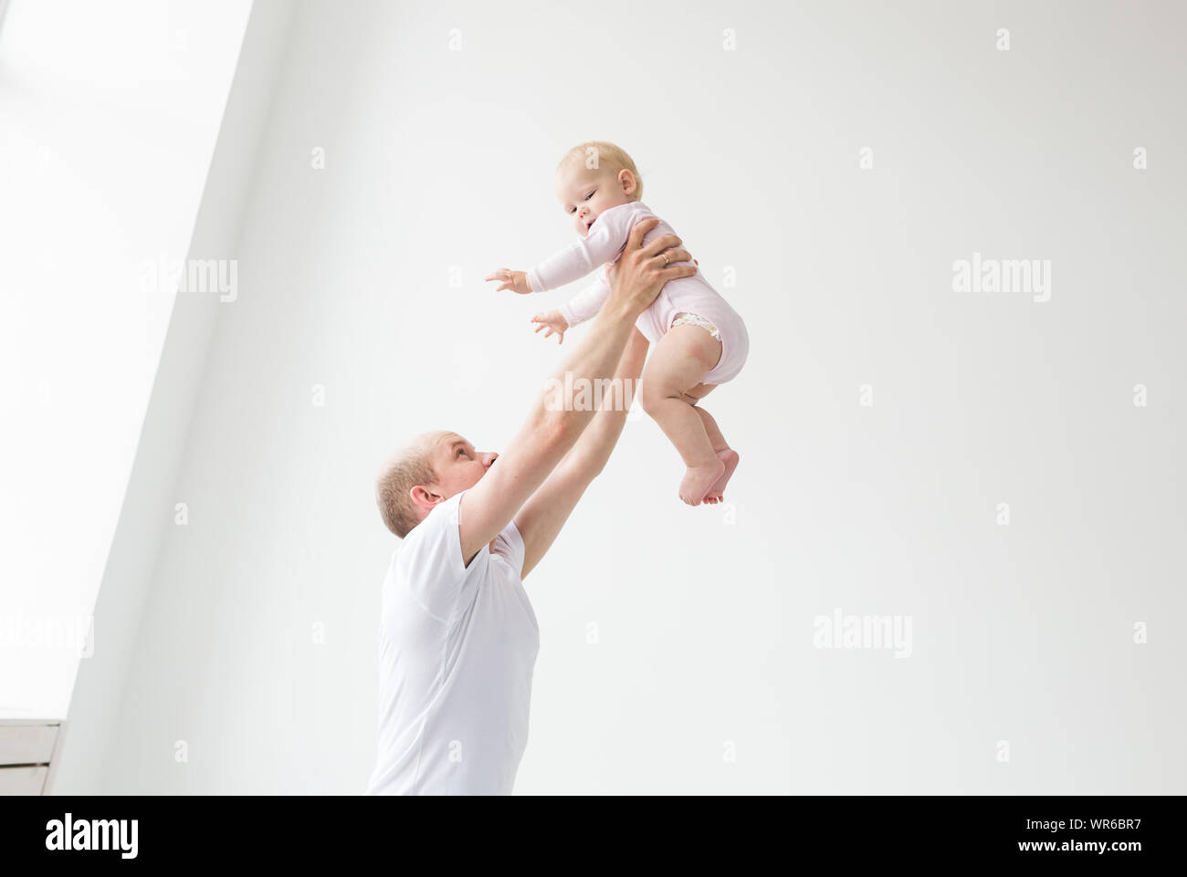 Father lifting baby girl. Happy father picks up and throws his lifting ...