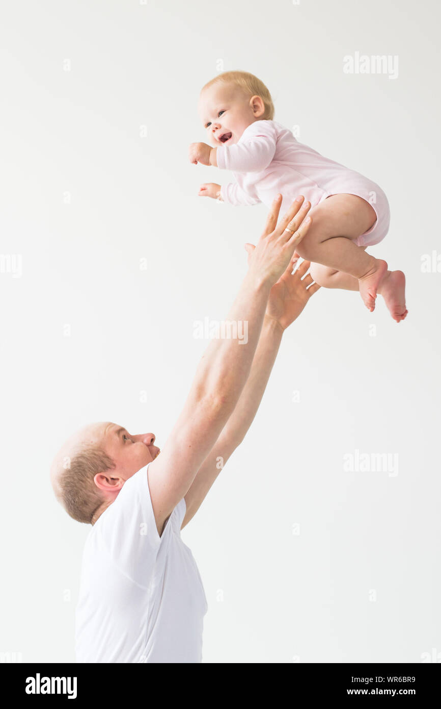 Father lifting baby girl. Happy father picks up and throws his lifting ...
