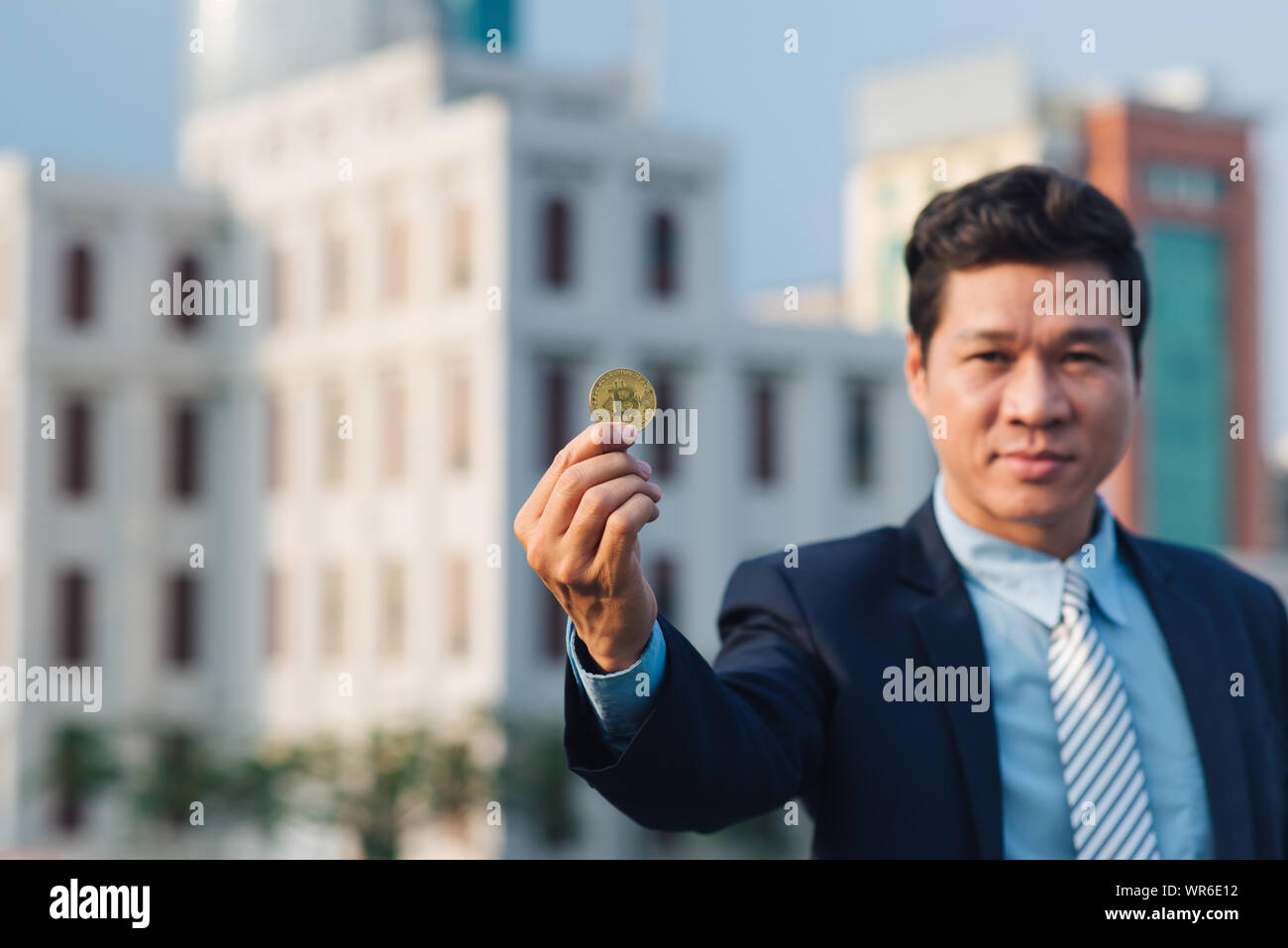 Golden bitcoin in hand of business man with black suit Stock Photo - Alamy