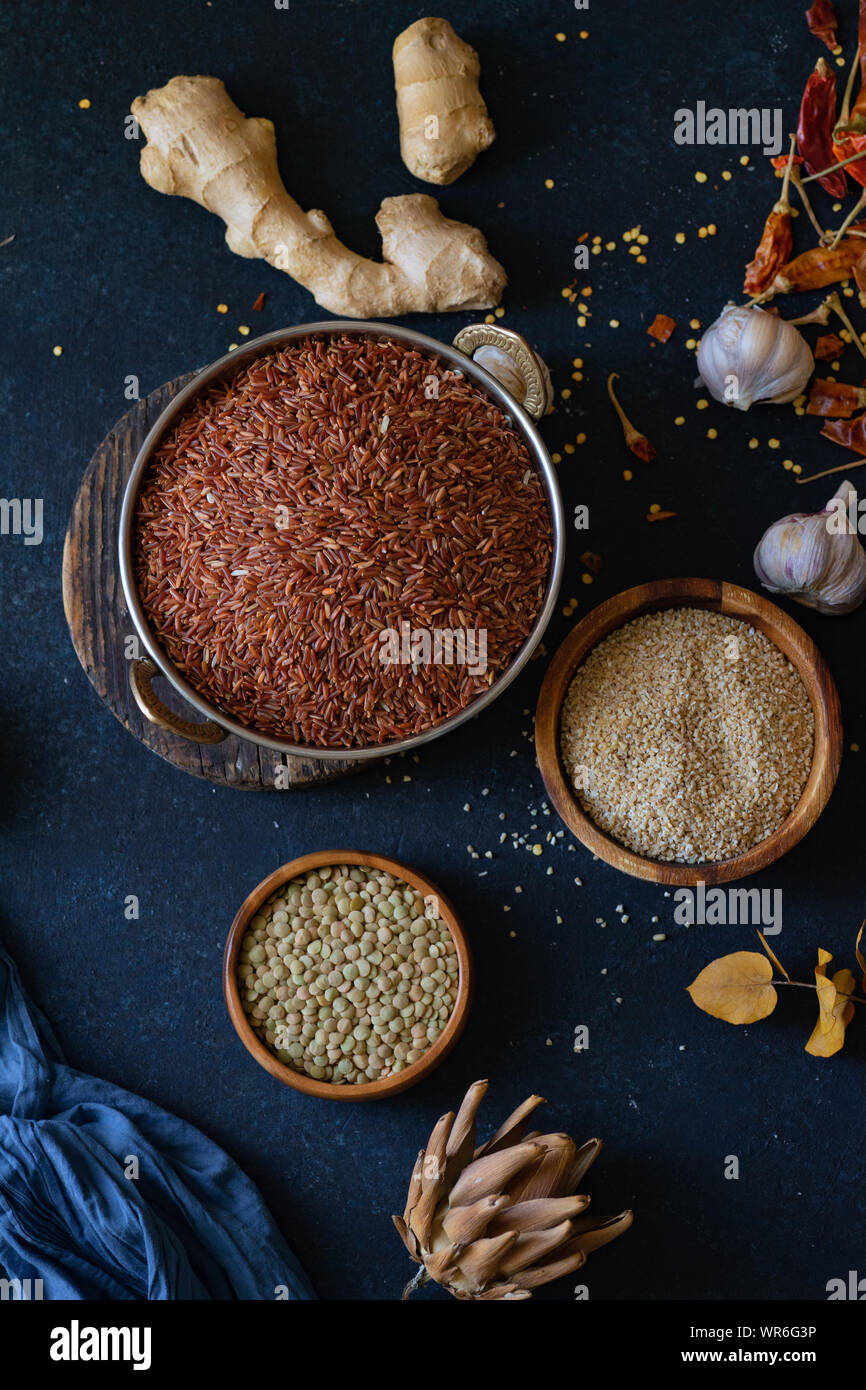 Various types of rice and grains with spices on blue background. Brown ...
