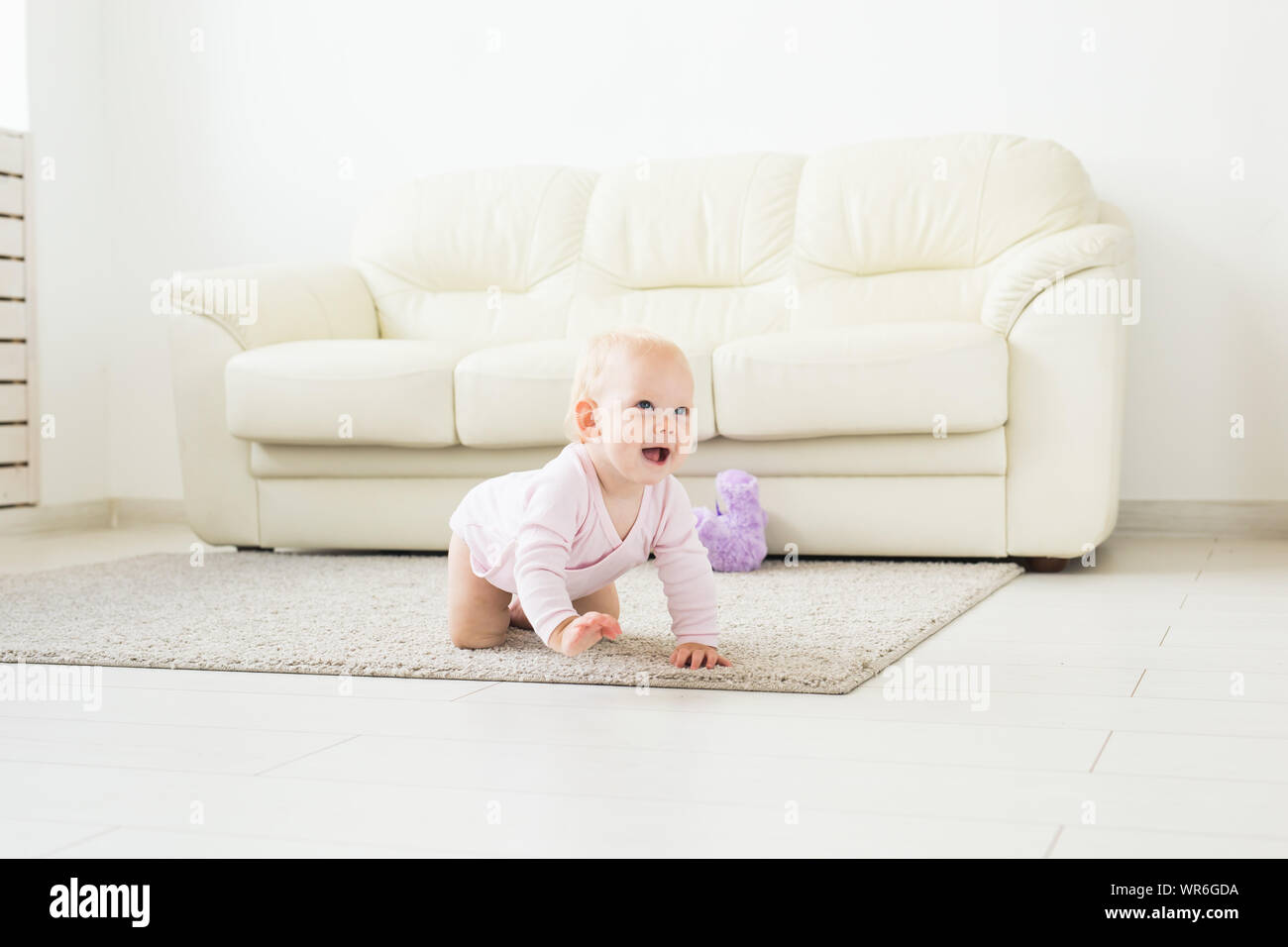 Smiling crawling baby girl at home on floor Stock Photo - Alamy