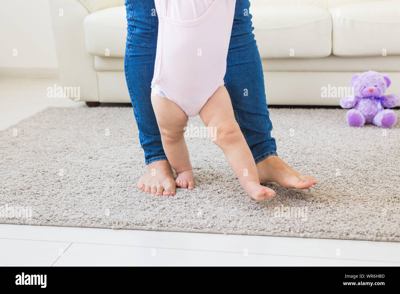 little girl first steps with the help of mom Stock Photo - Alamy