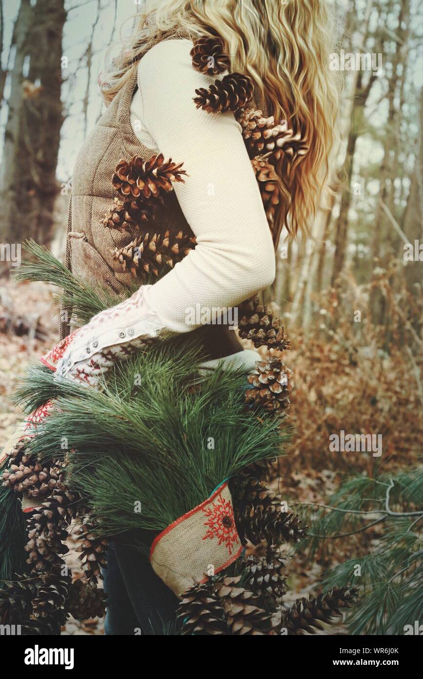 Side View Of Woman With Pine Cones Standing At Forest Stock Photo - Alamy